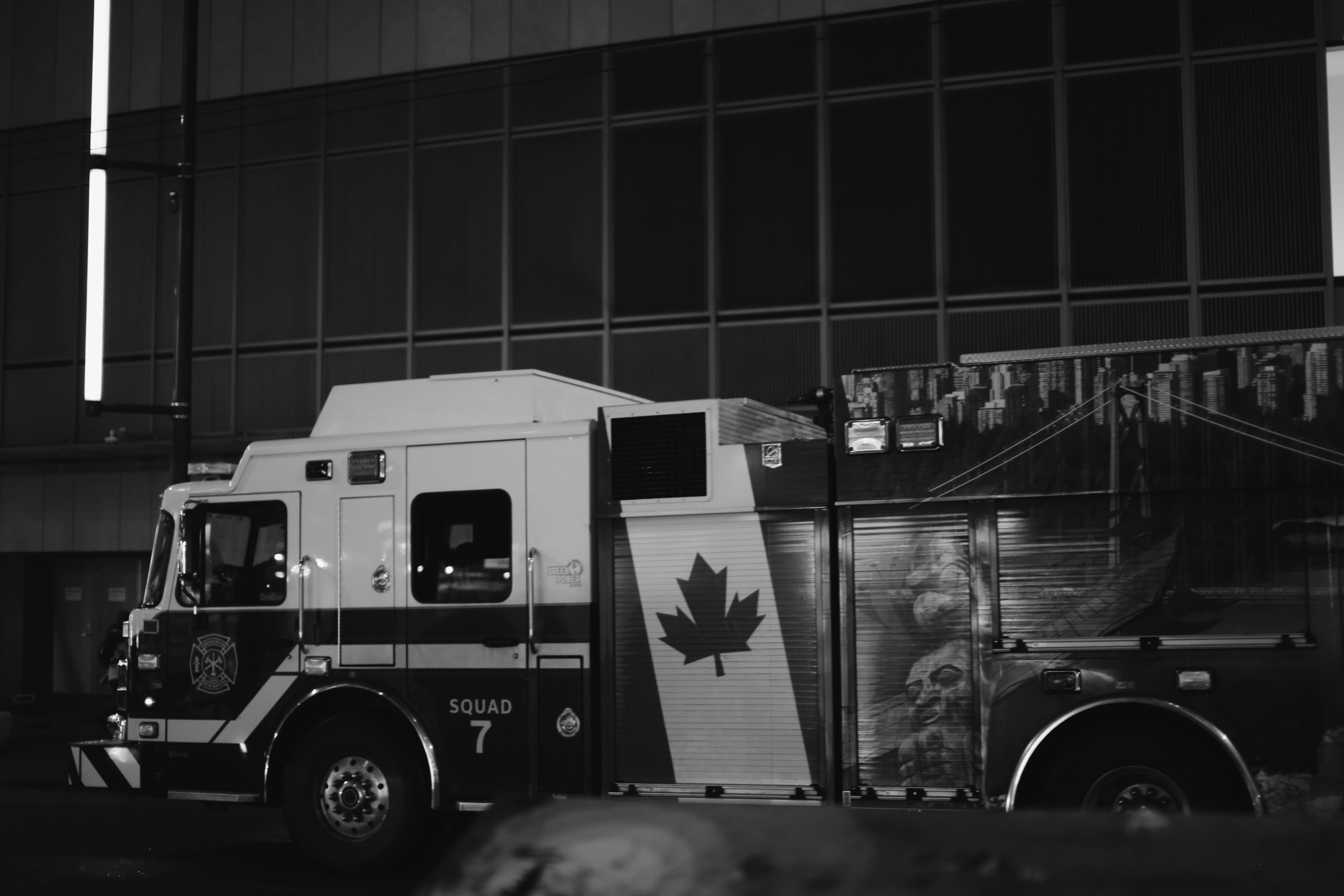 Midnight Response: A Canadian Fire Engine Rests beside a Glass Facade