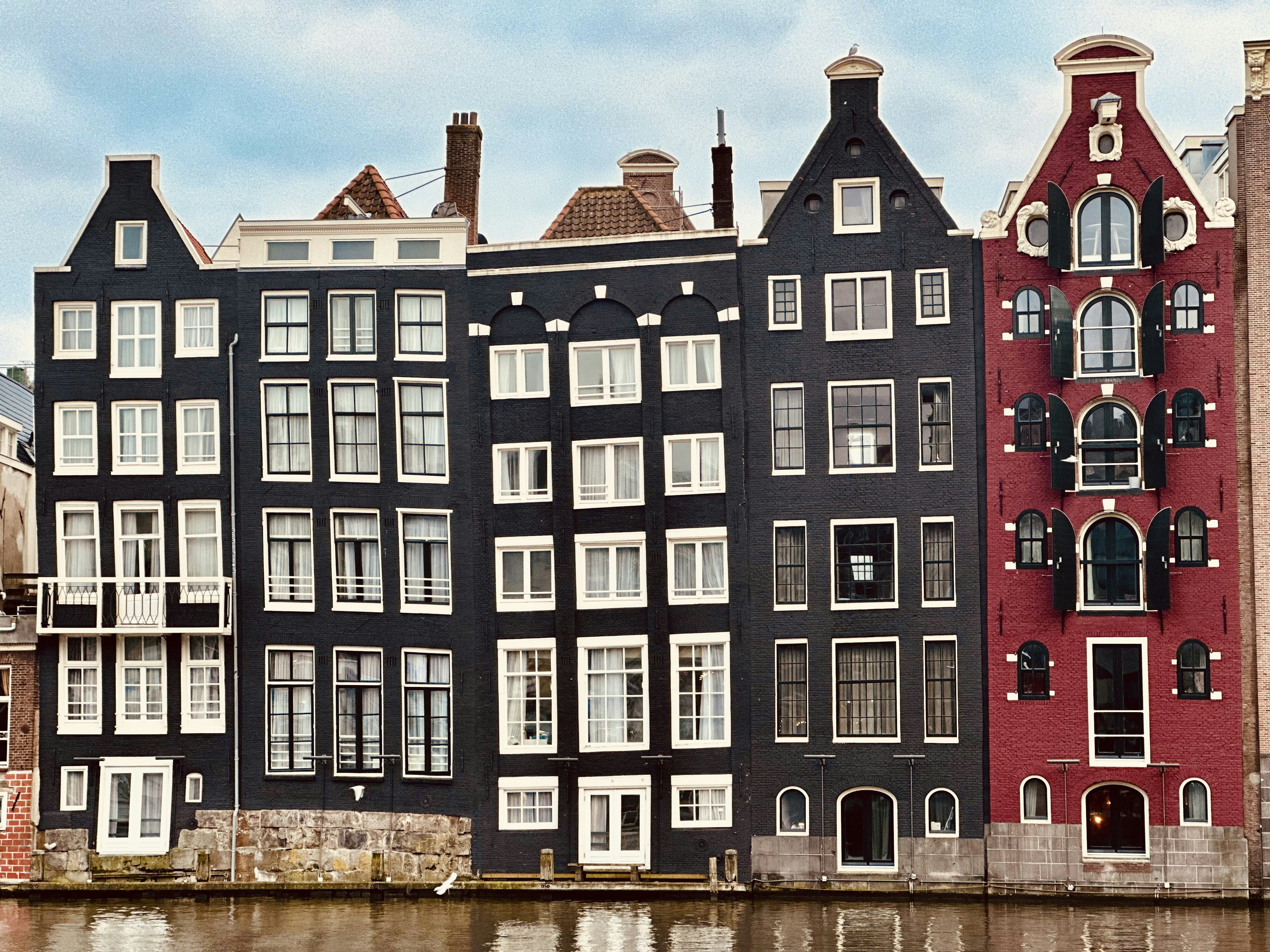 Una hilera de edificios junto a un cuerpo de agua foto – Imagen de ...