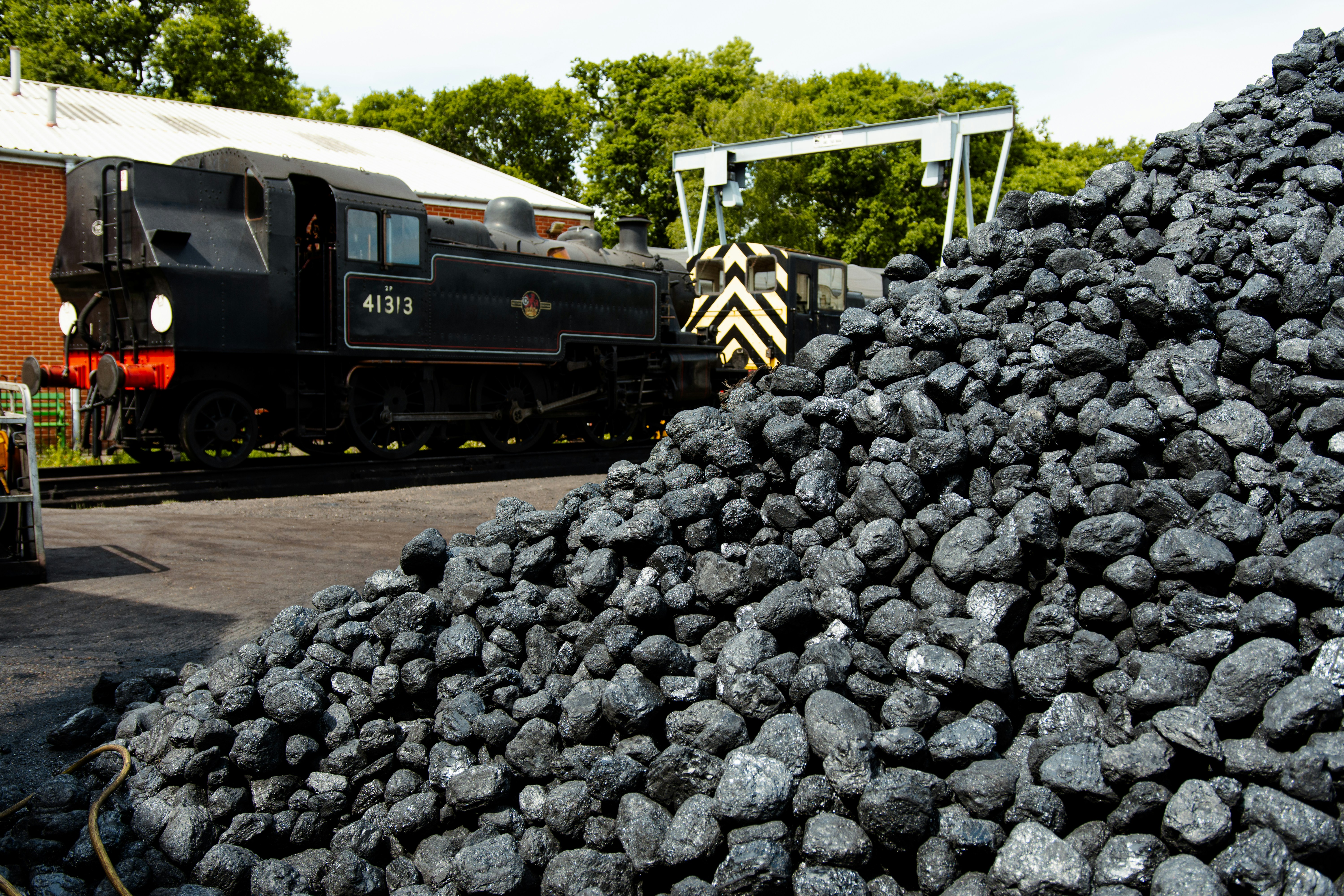 A train traveling past a pile of coal photo – Free Coal Image on Unsplash