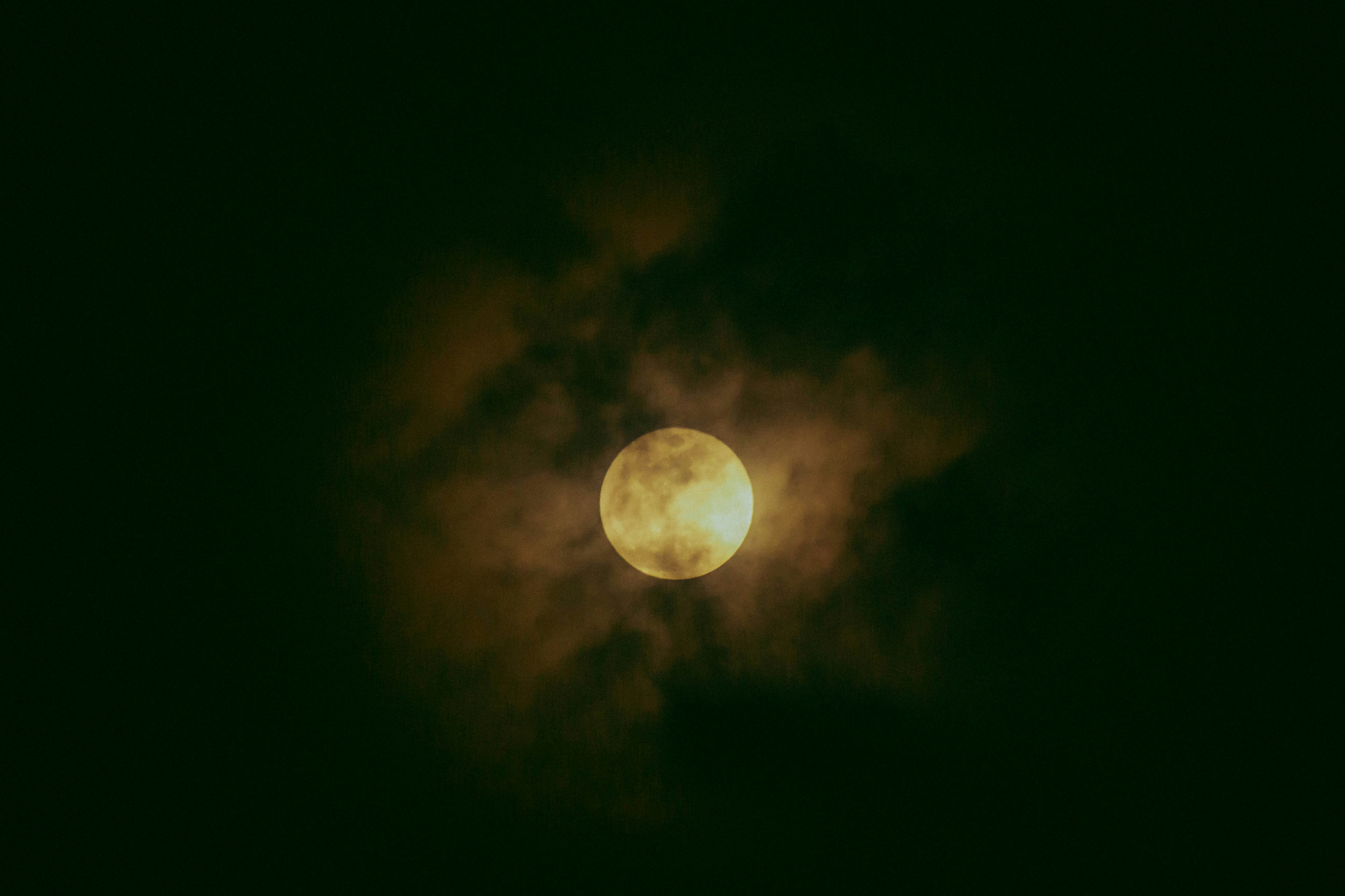 A full moon seen through the clouds in the night sky photo – Free Moon ...