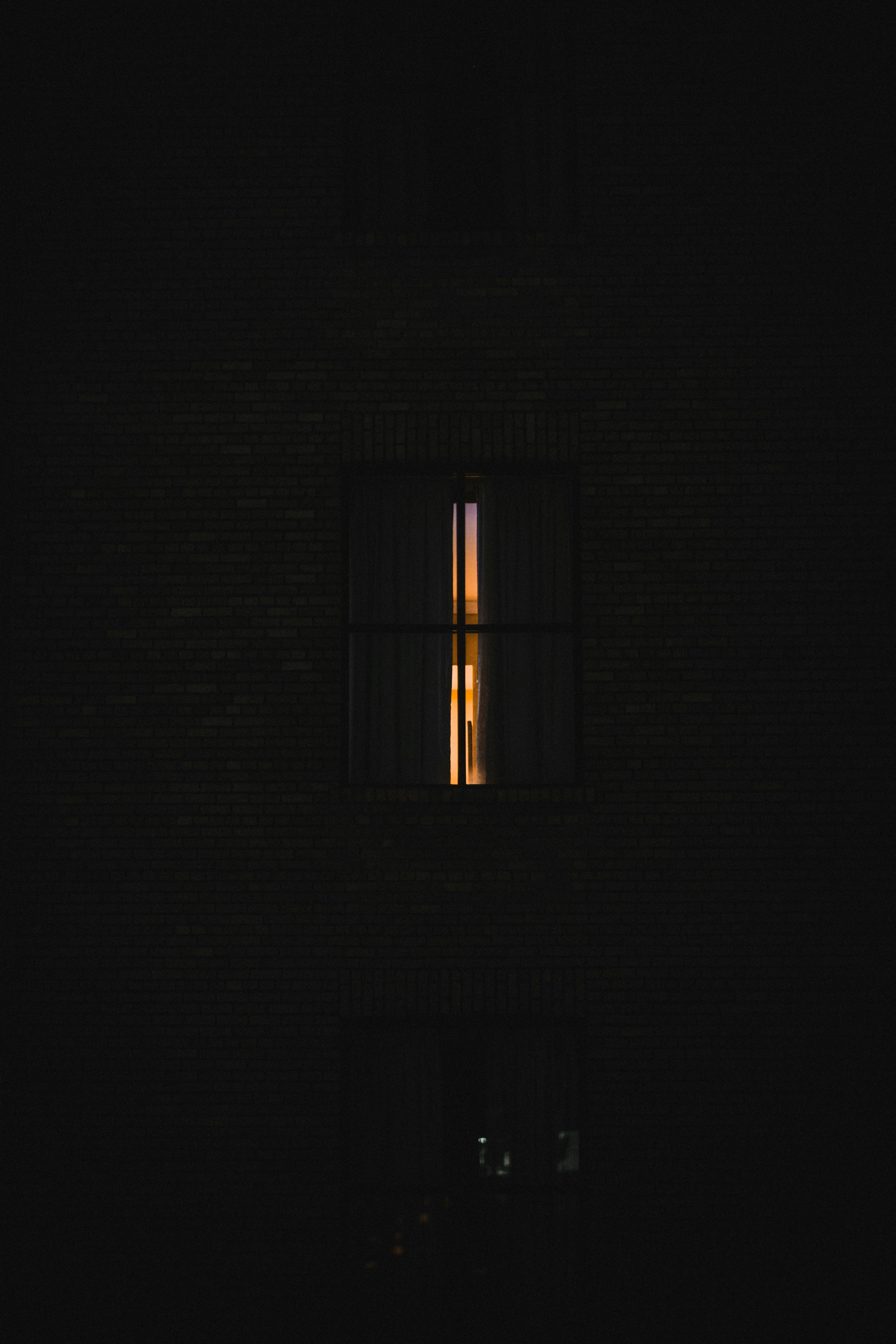 A dark room with a window lit up at night photo – Free Building Image ...