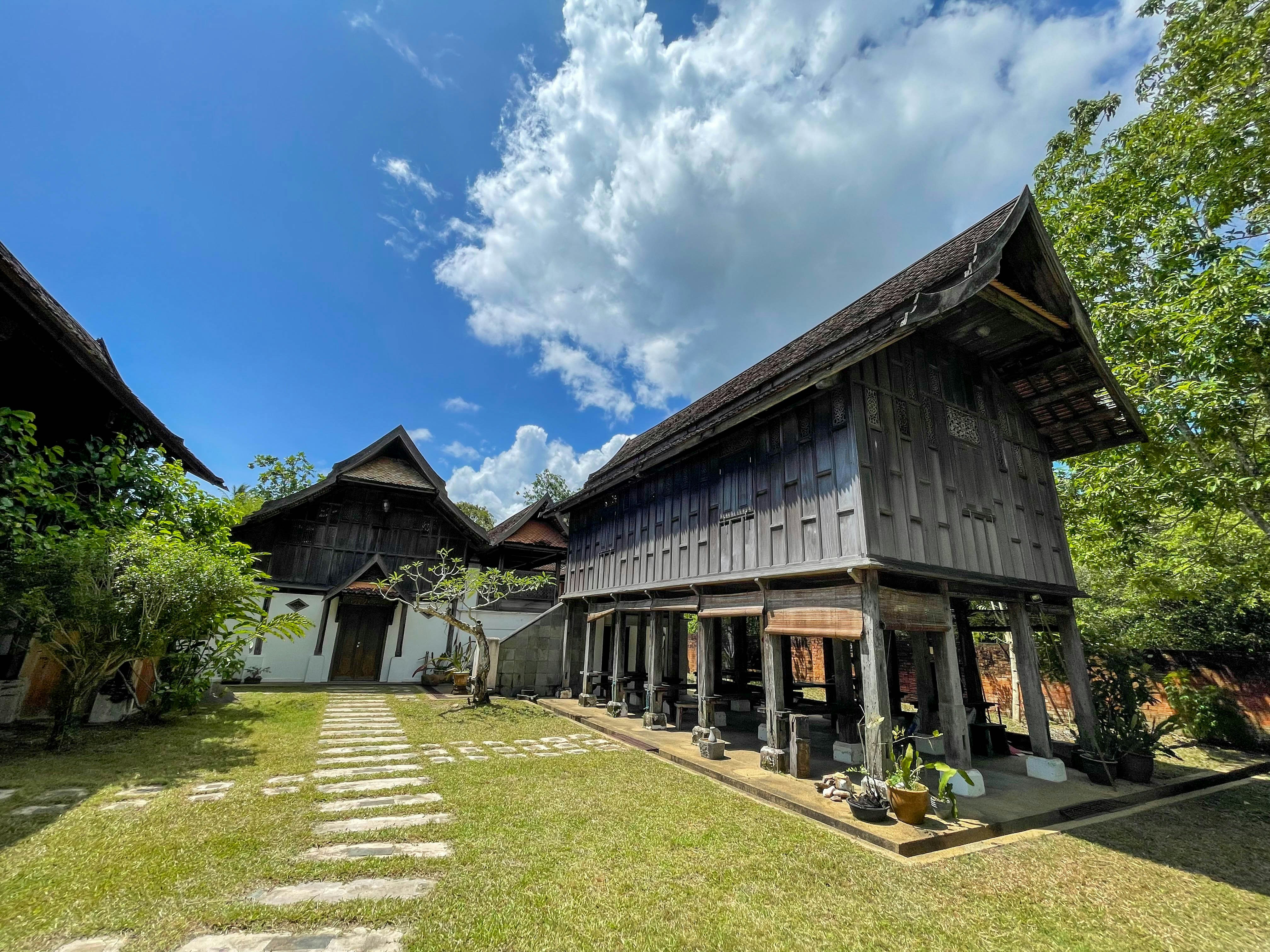 Bakawali Sari Warisan | a large wooden building sitting on top of a lush green field