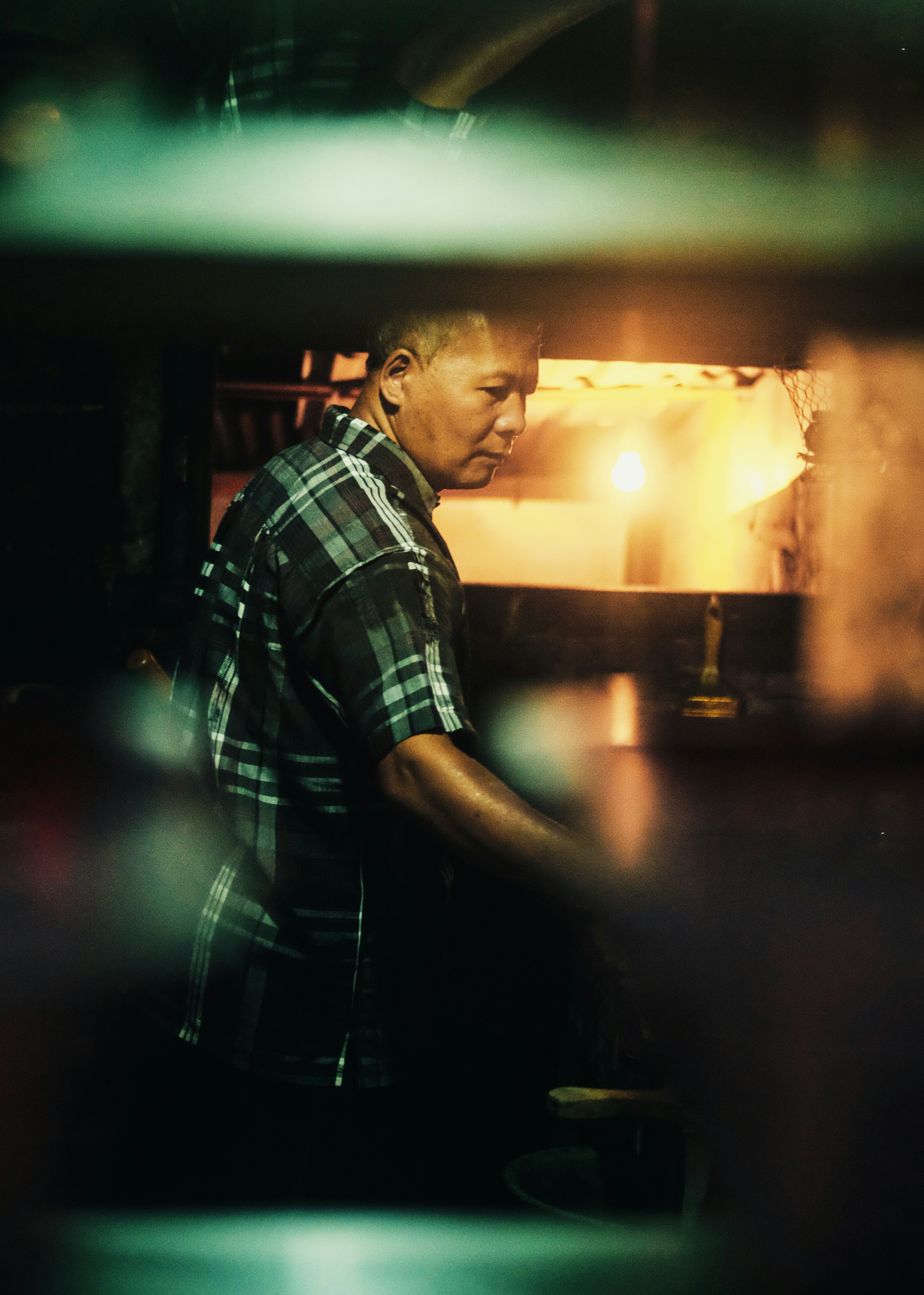 Plaid Portrait Under Ember Light in a Quiet Kitchen