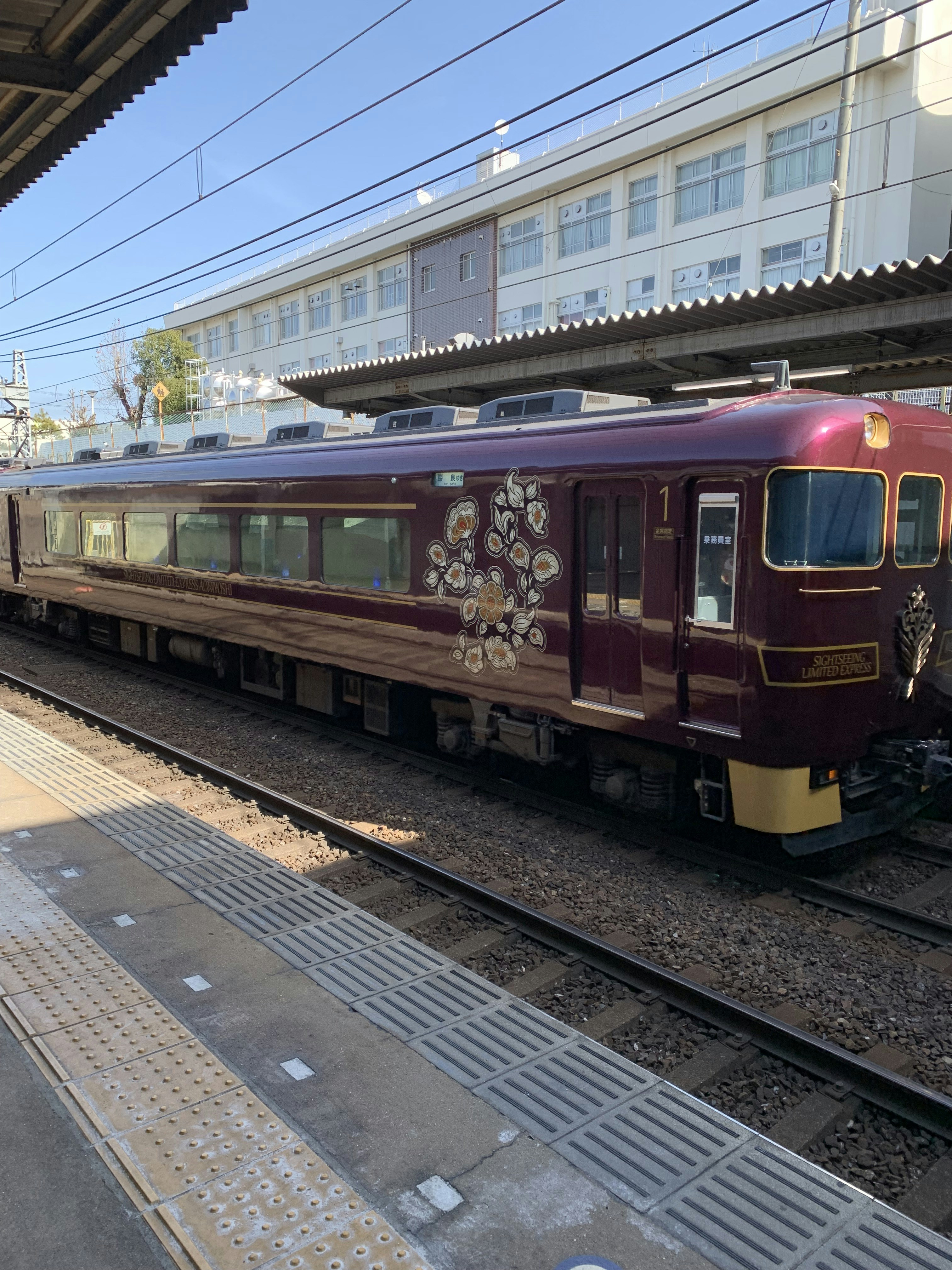 A maroon train pulling into a train station photo – Free Image on Unsplash