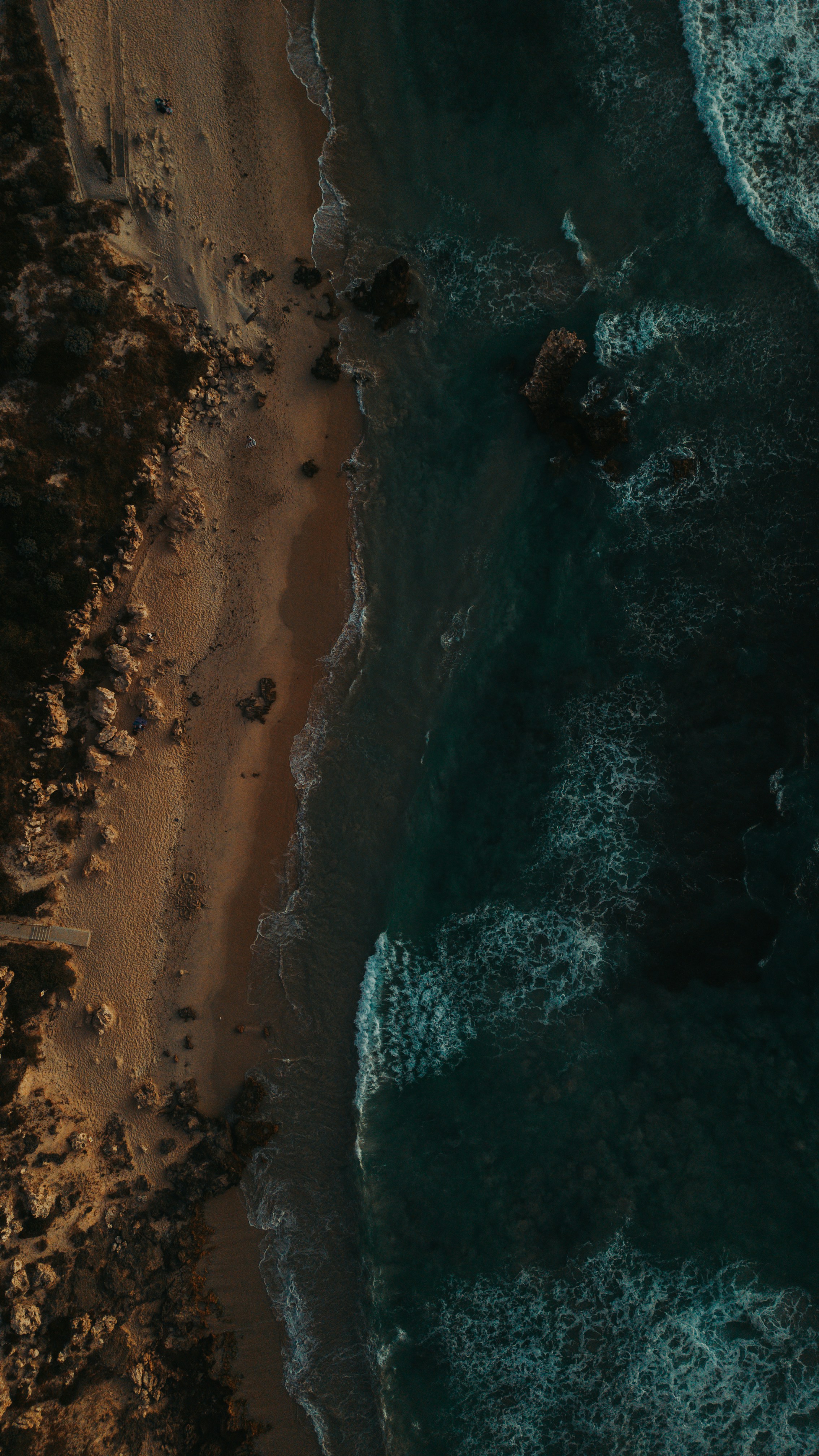 Coastal Edge: Sunset tide at the rocky shoreline