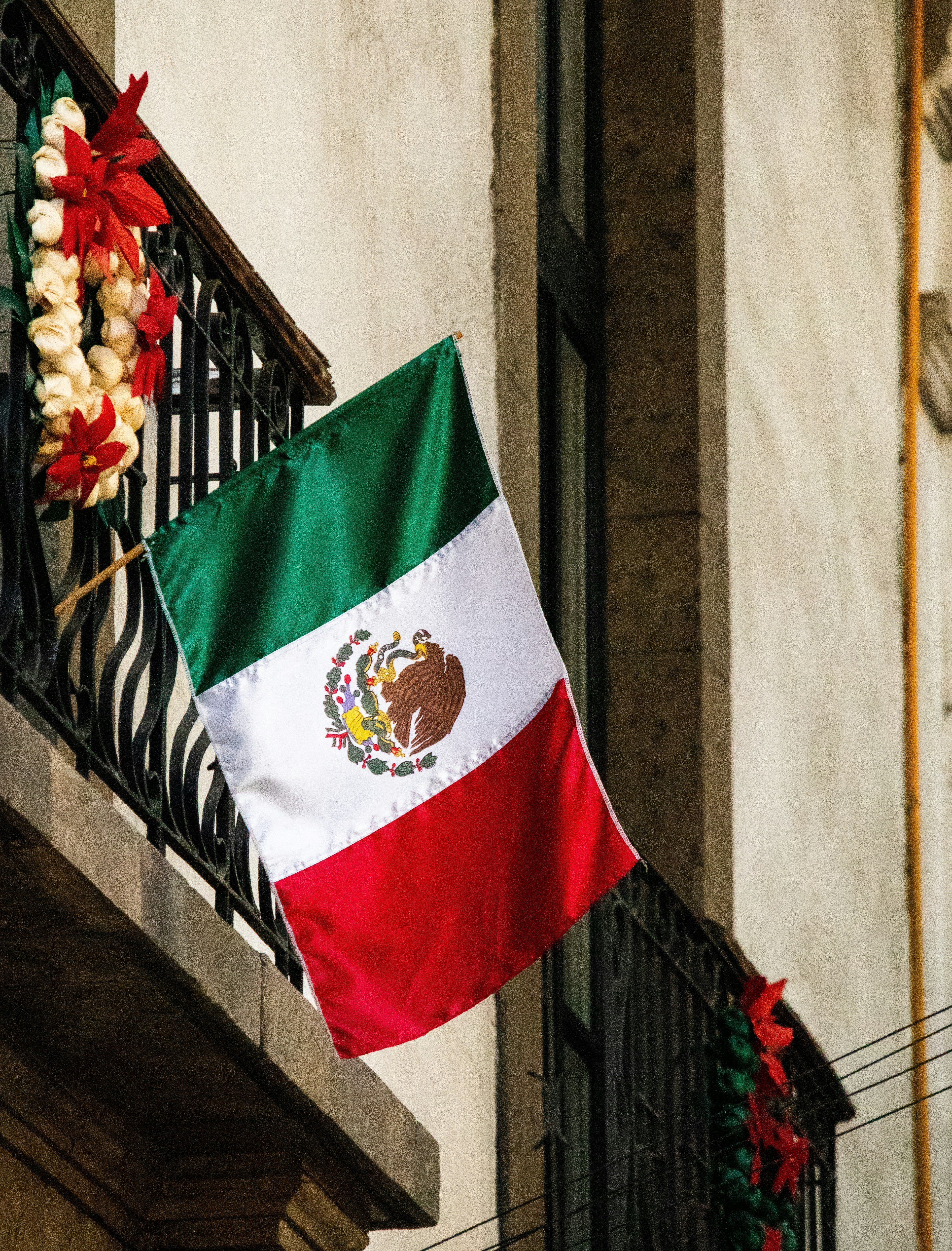 Flag of Mexico Draped Over a Balcony Framing a Historic Facade