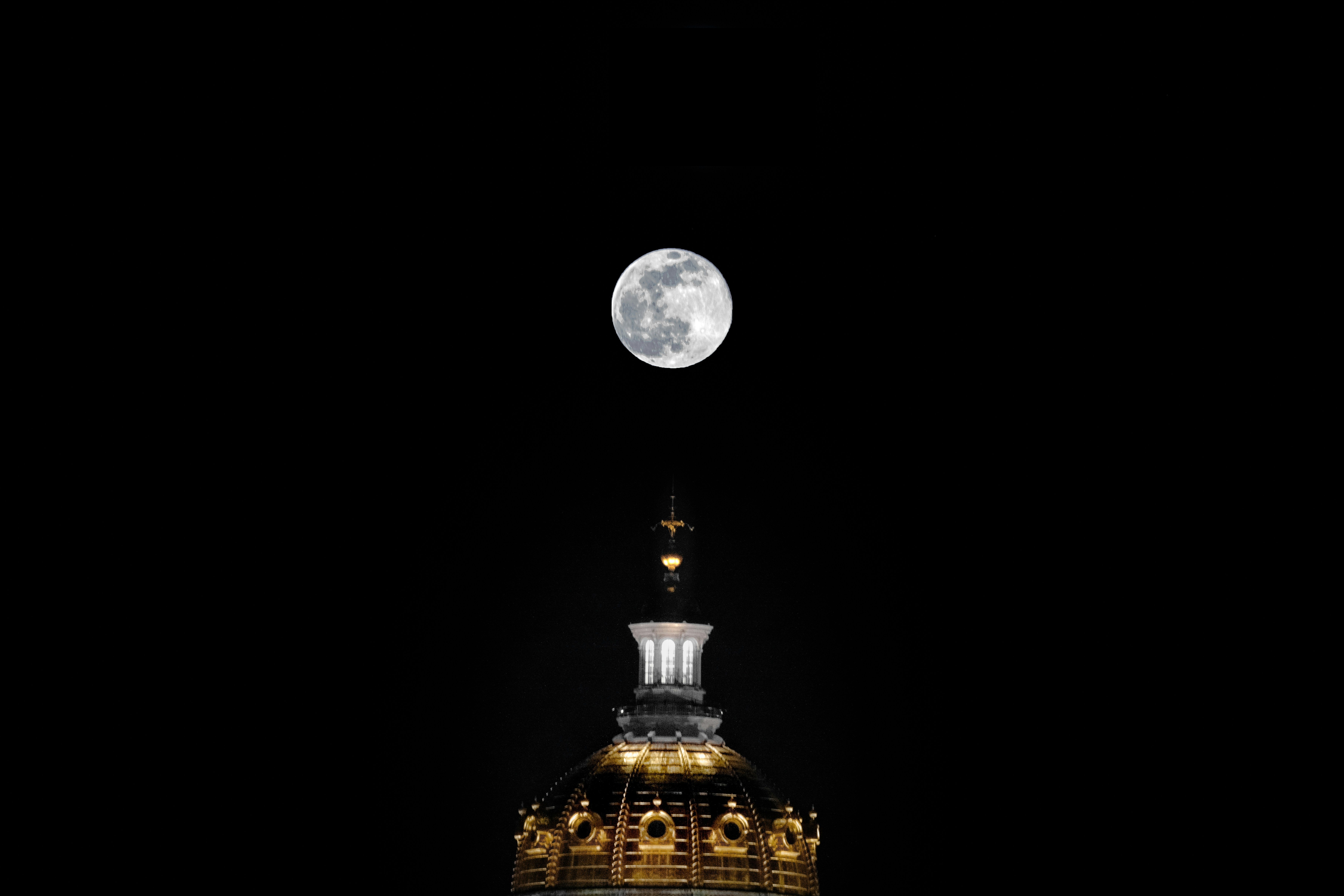 A building with a clock tower and a full moon in the background photo ...
