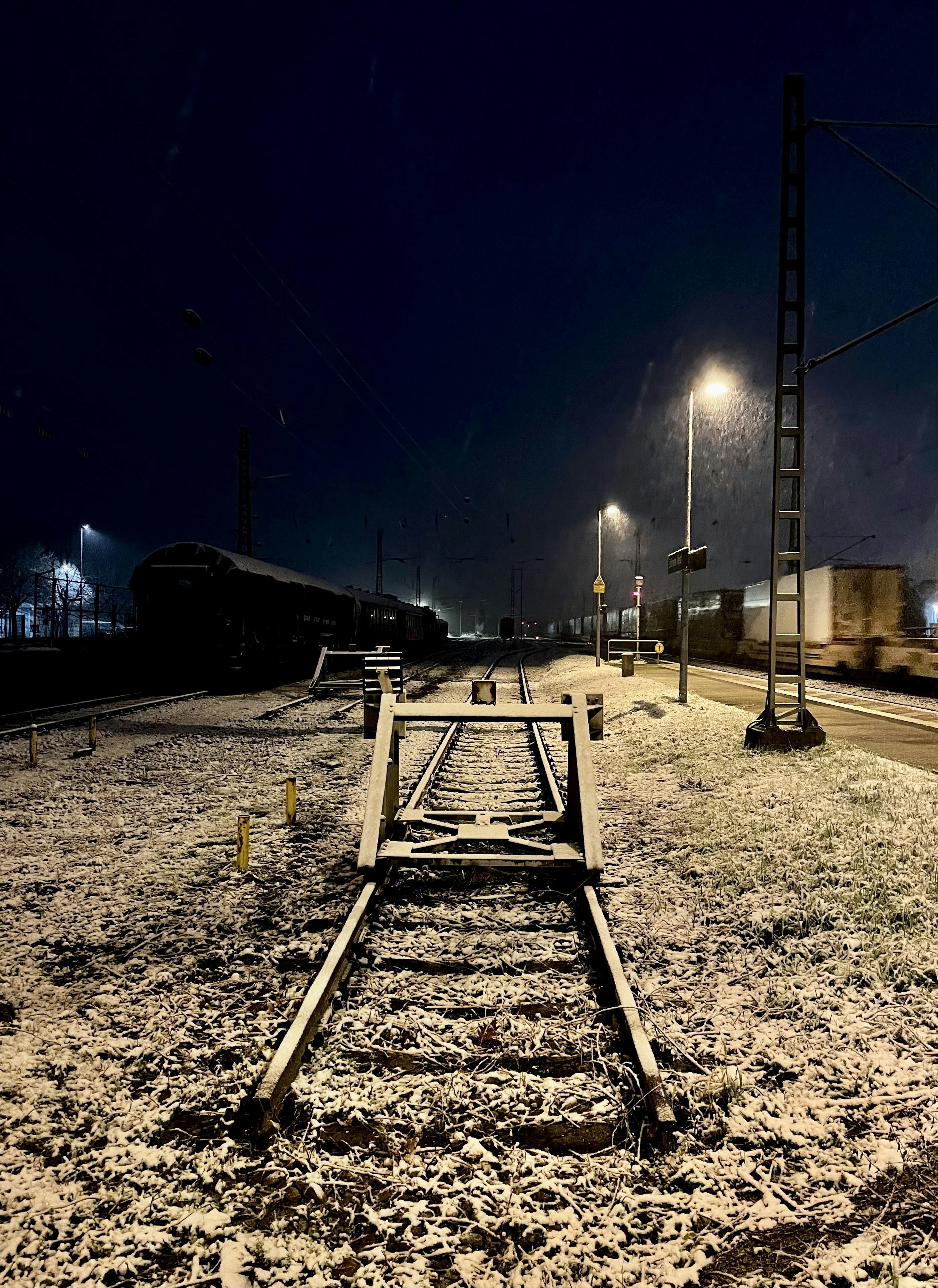 Night at the Rails: Frosted Tracks Under Streetlight Gaze
