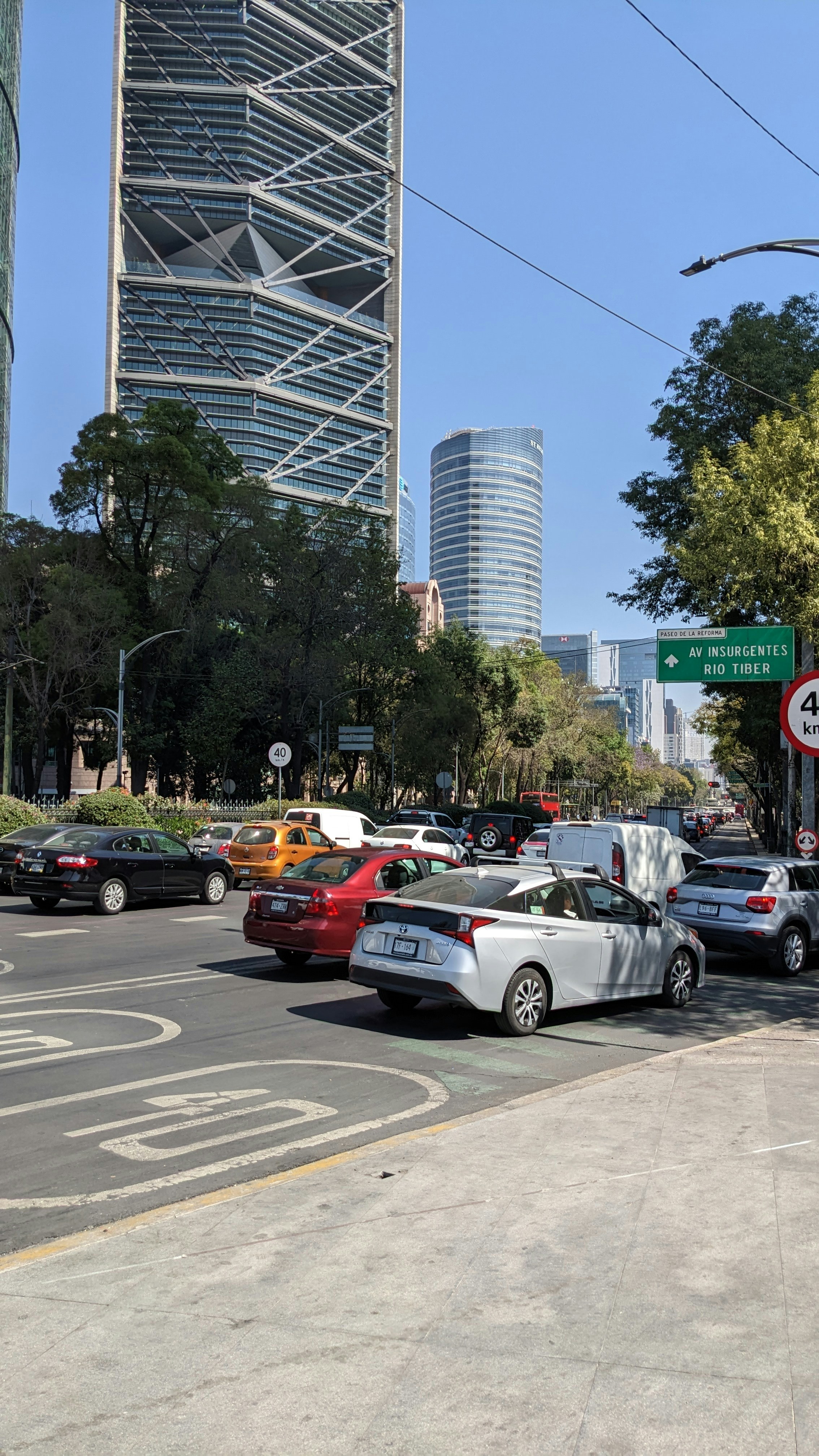 Crisscrossed Tower Over a Lively Avenida