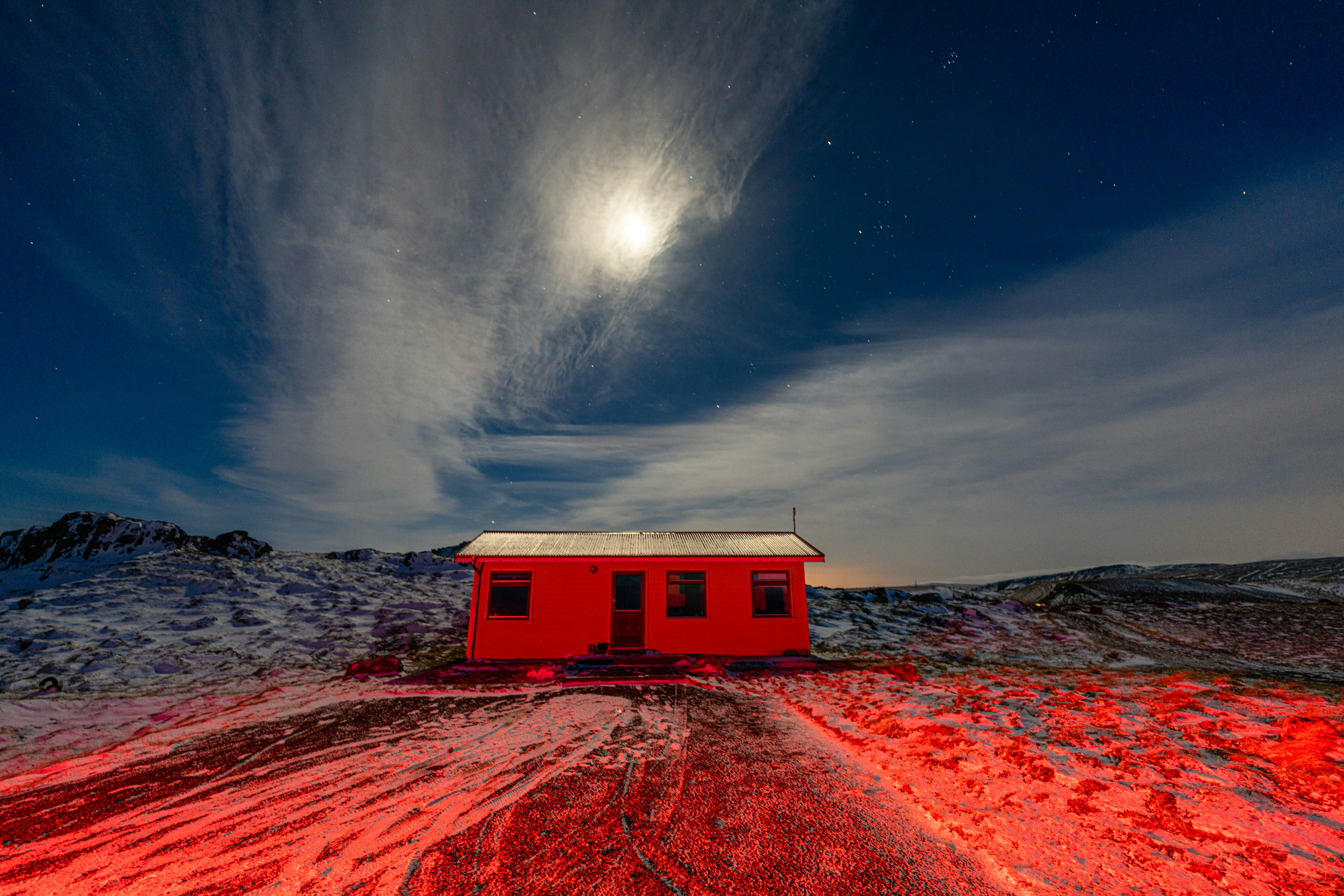 Crimson Cabin Anchored in a Moonlit Arctic Plain