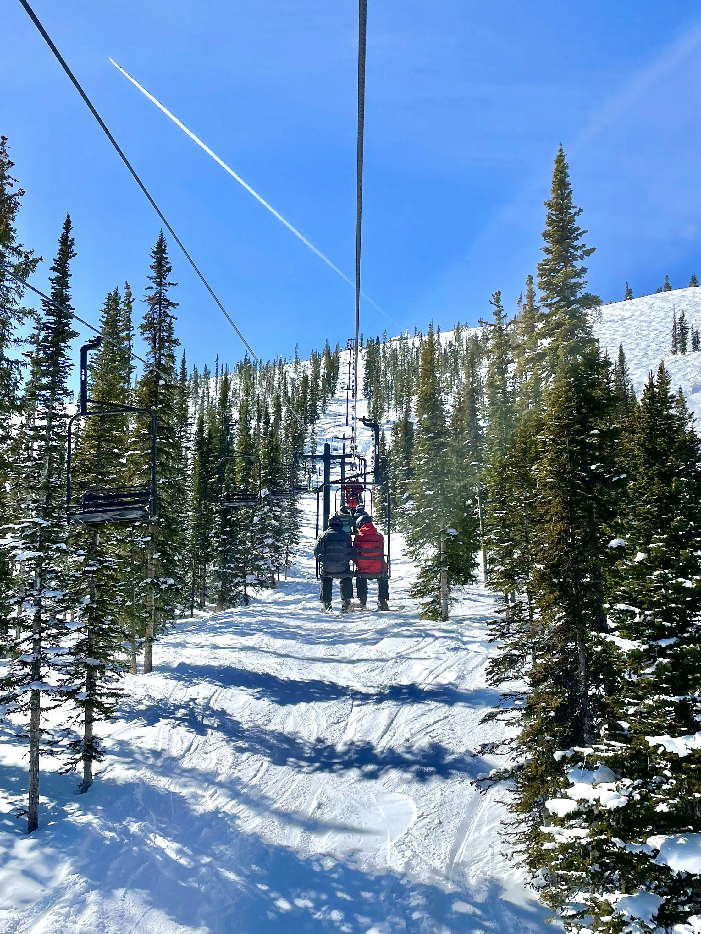 Ridge Lift: Snow-Chair Ascent Under a Cerulean Sky