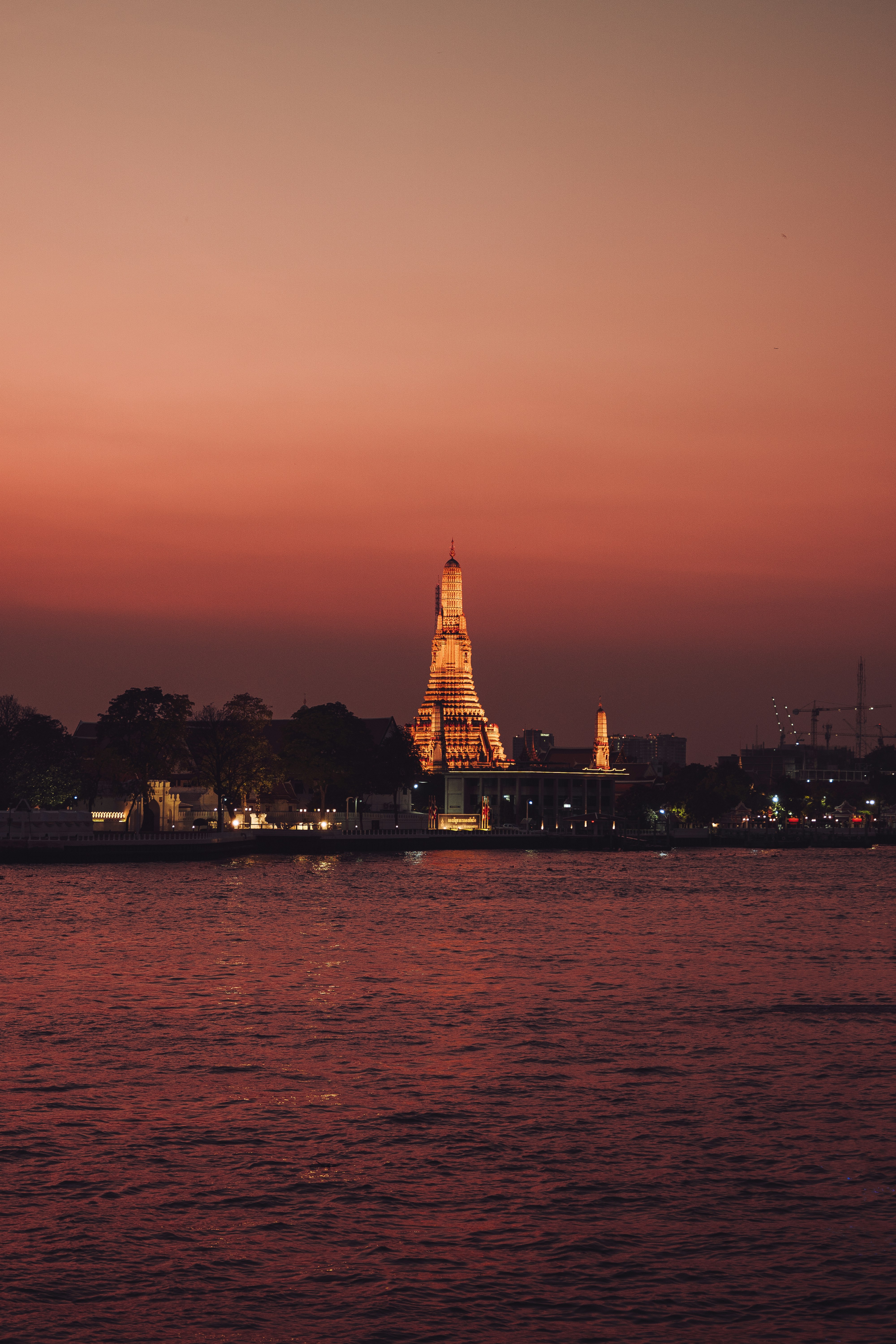 Ember-Spired Temple Silhouette Over a Velvet River at Dusk