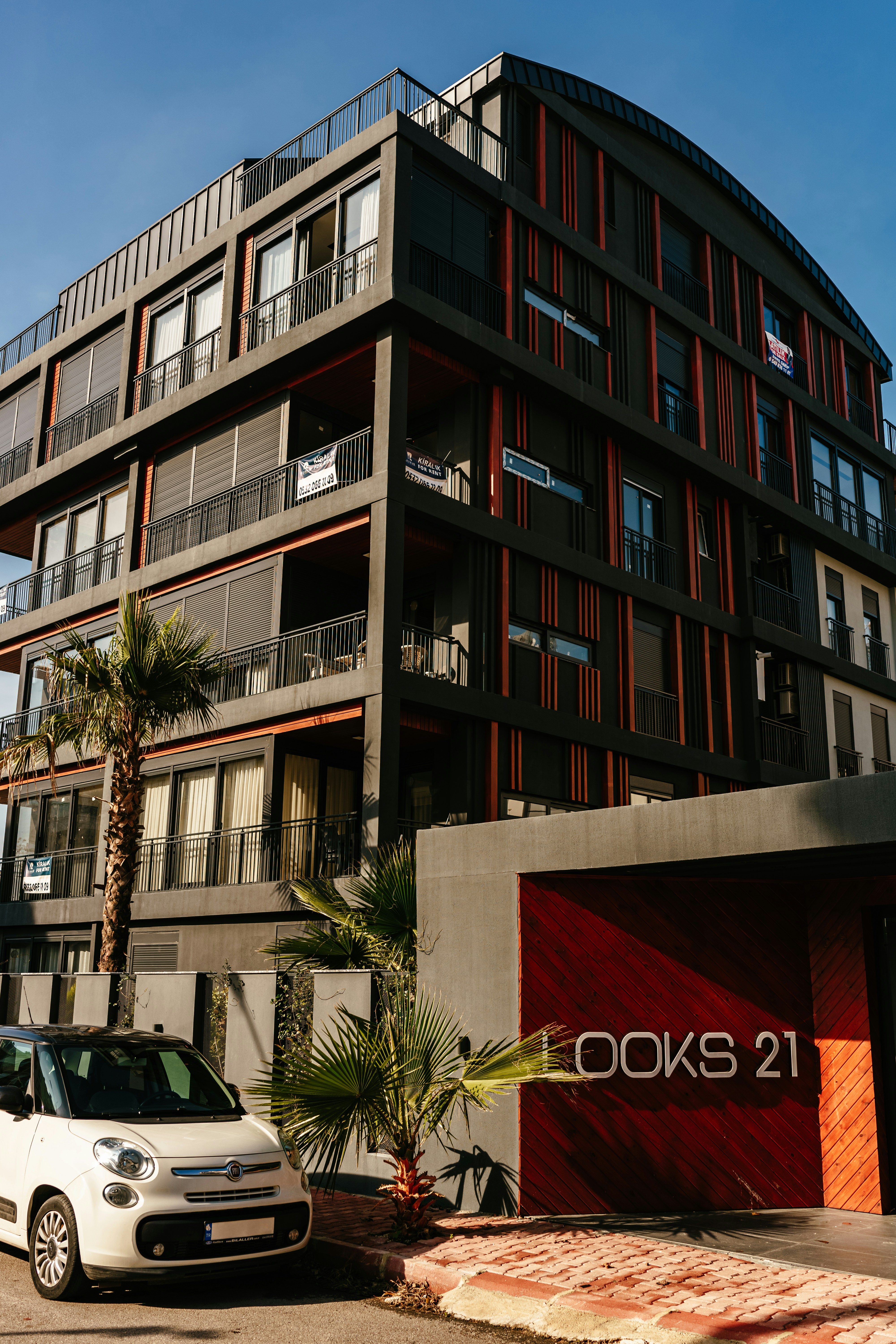 A white car parked in front of a tall building photo – Free Building ...