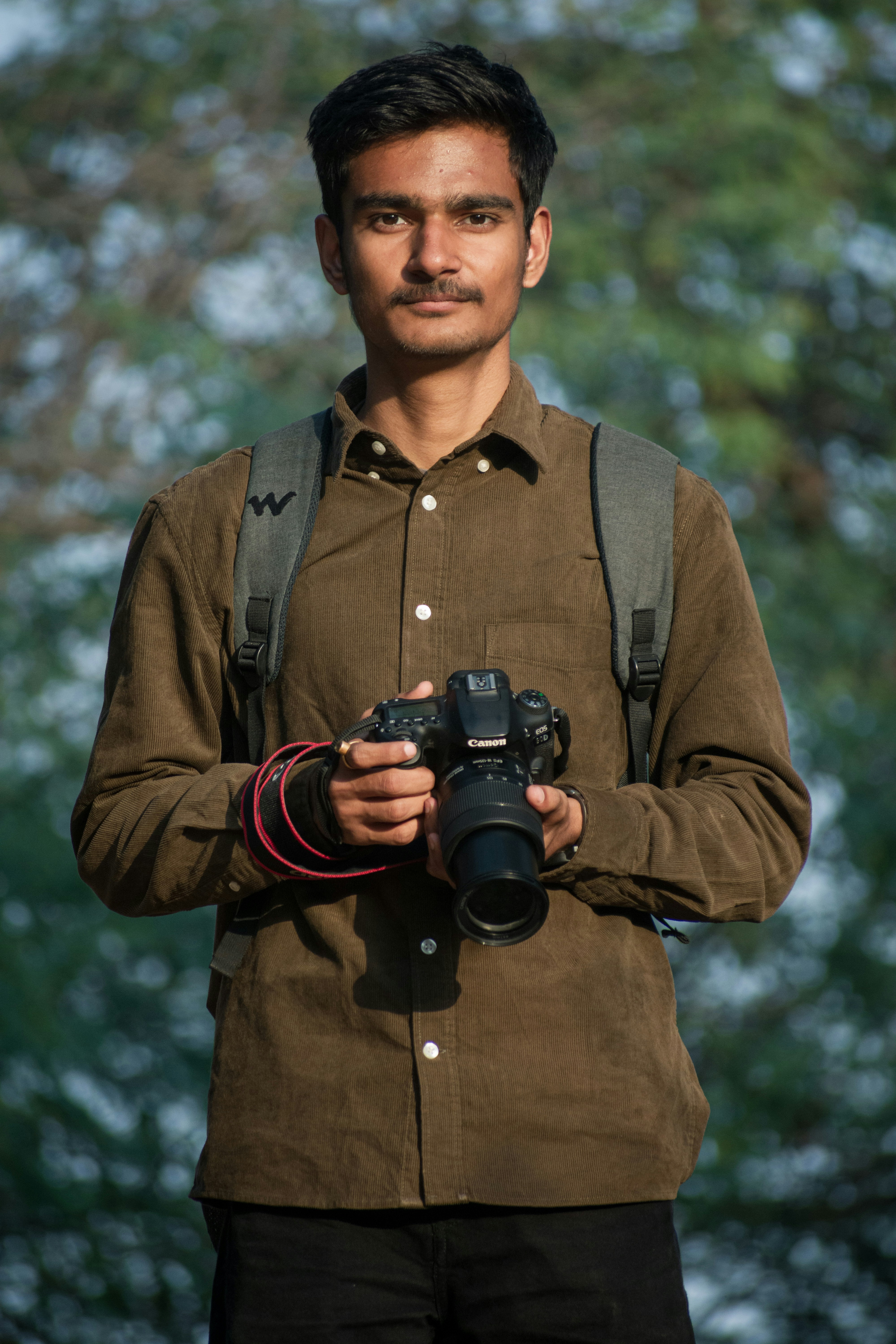 Young Indian photographer holding a professional dslr camera. Sanket Mishra Photography