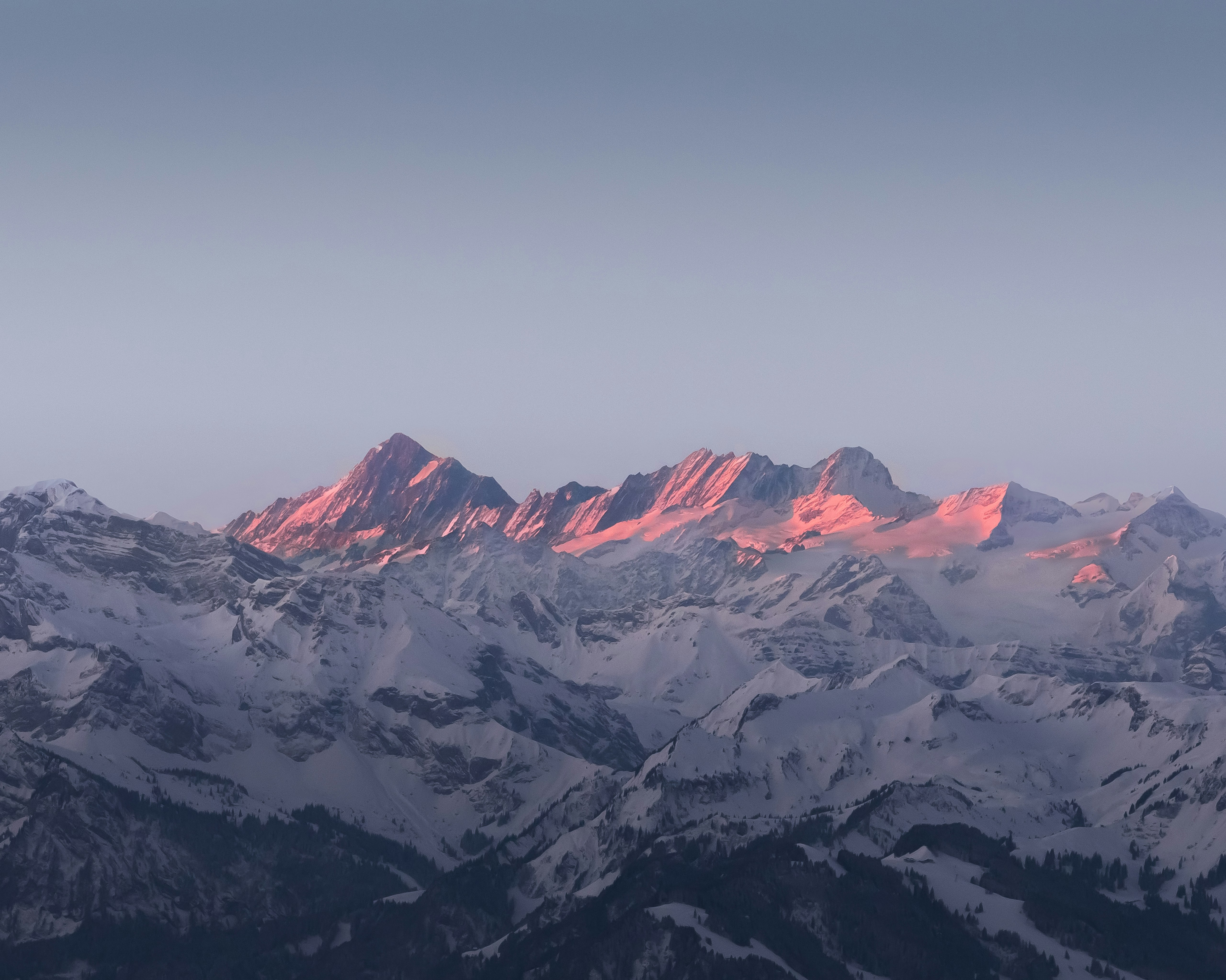 High mountain peaks in the swiss alps at dawn | a view of a mountain range at sunset