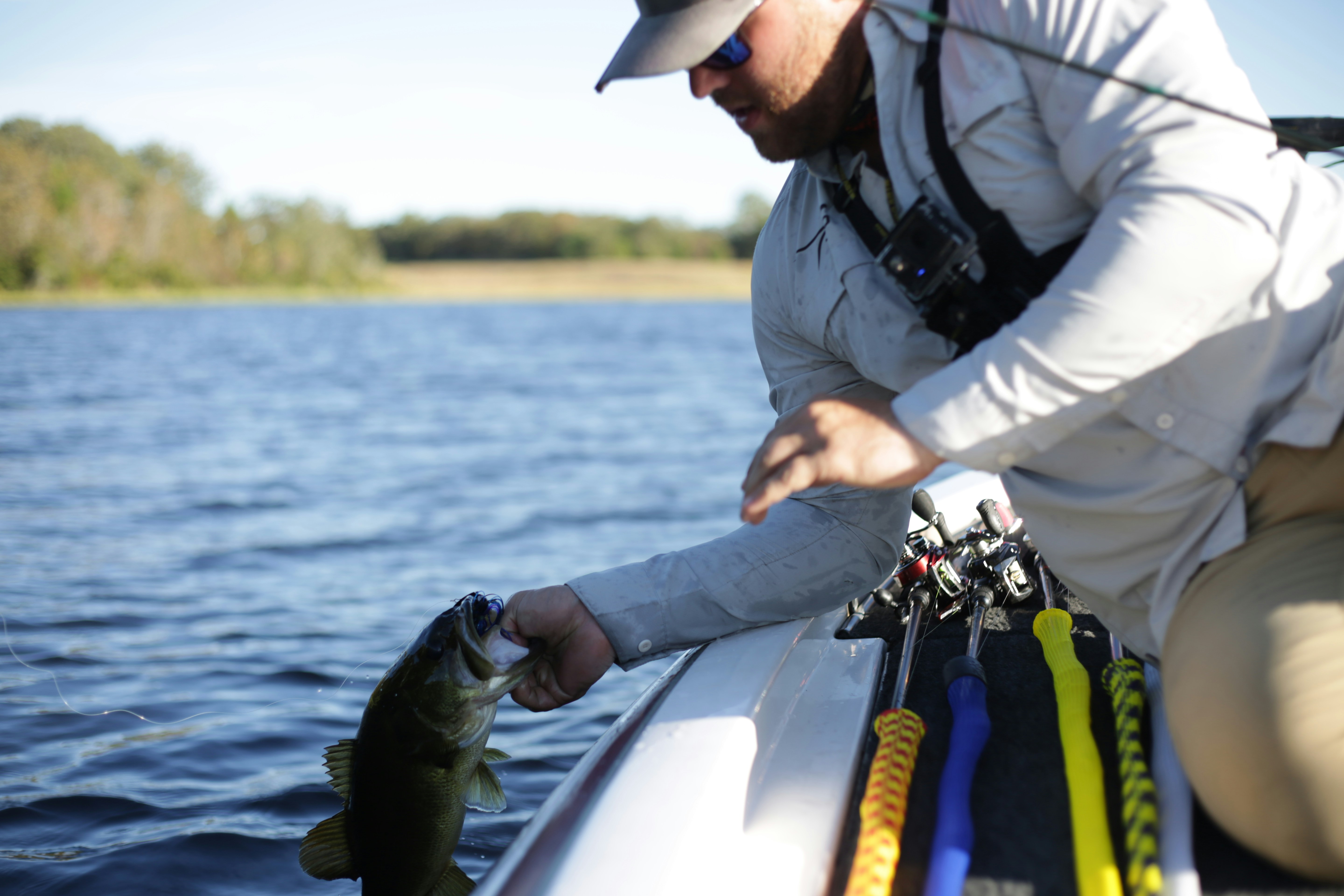 a man holding a fish while sitting on a boat