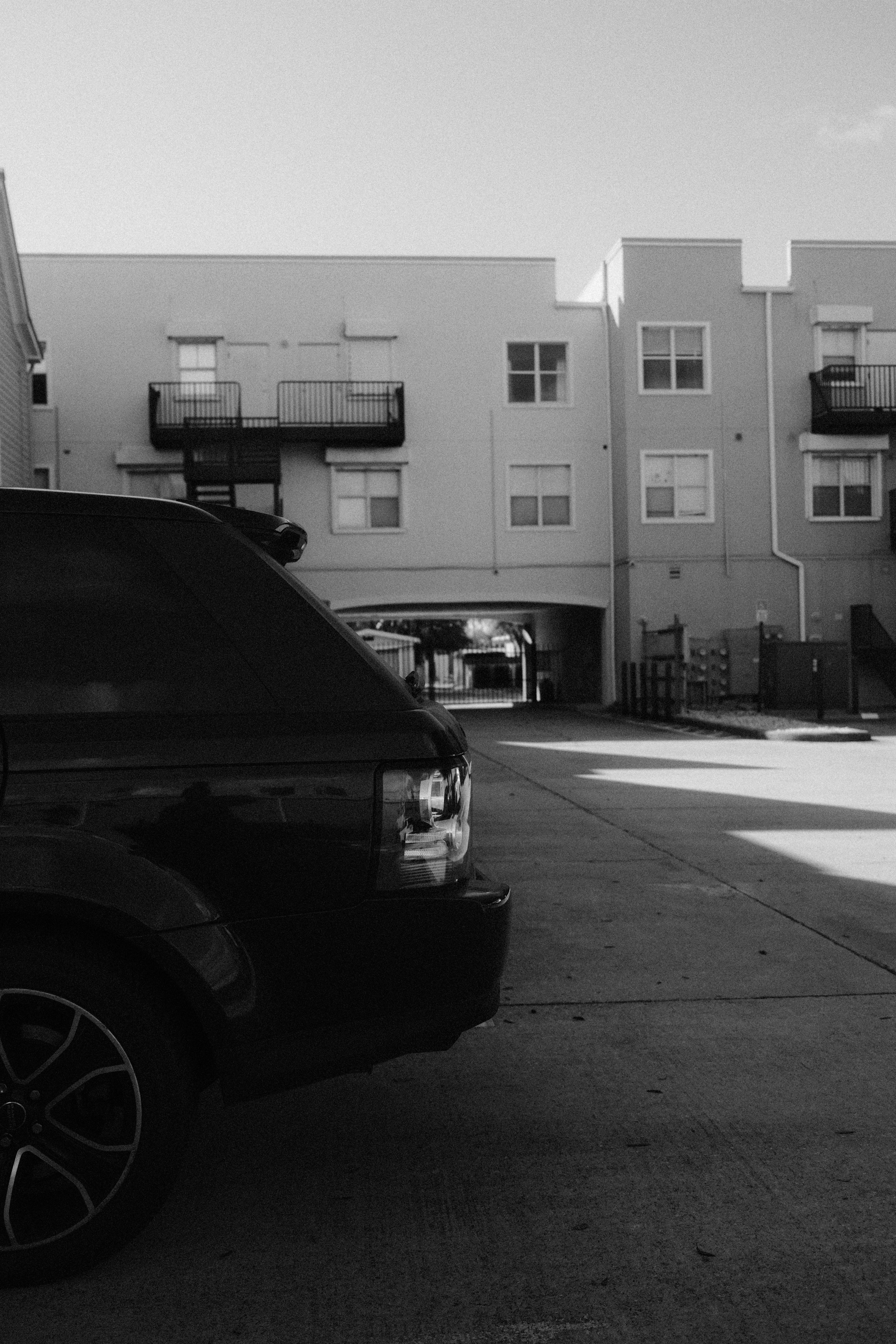 a black and white photo of a car parked in front of a building