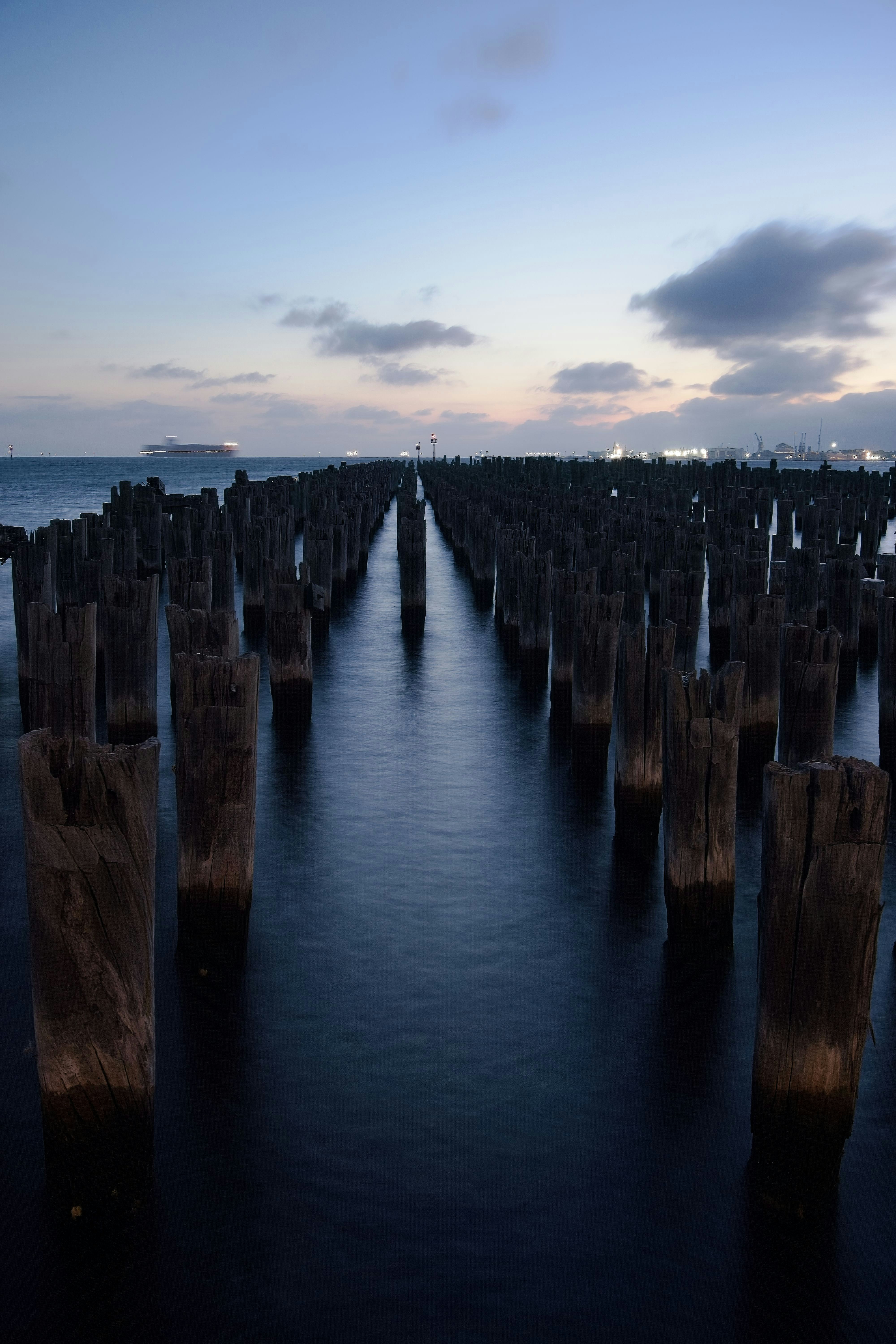 Vanishing Piers at Blue Hour: Converging Wooden Columns Toward the Horizon