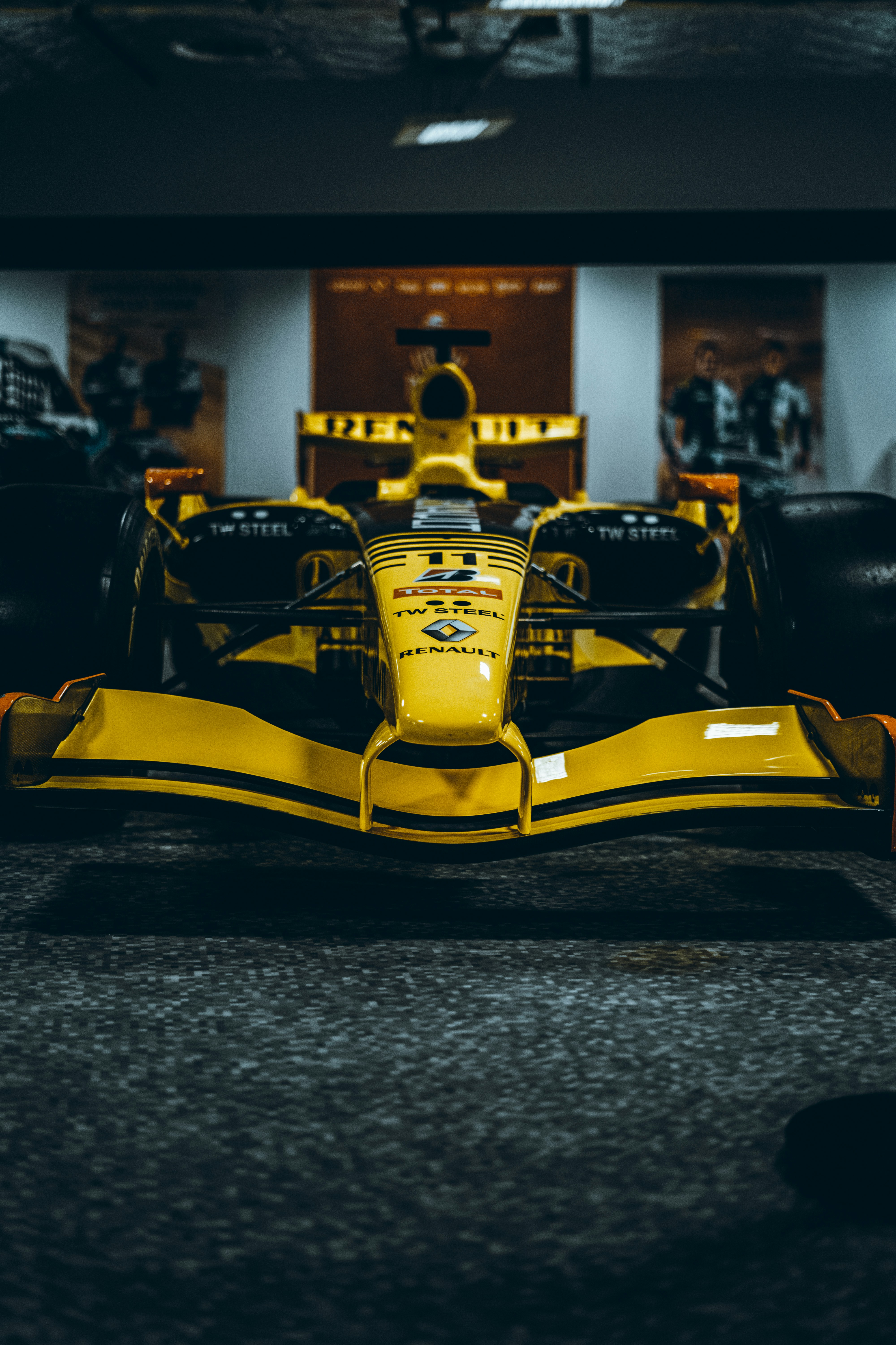 A yellow race car parked in a garage photo – Free Formula one Image on ...