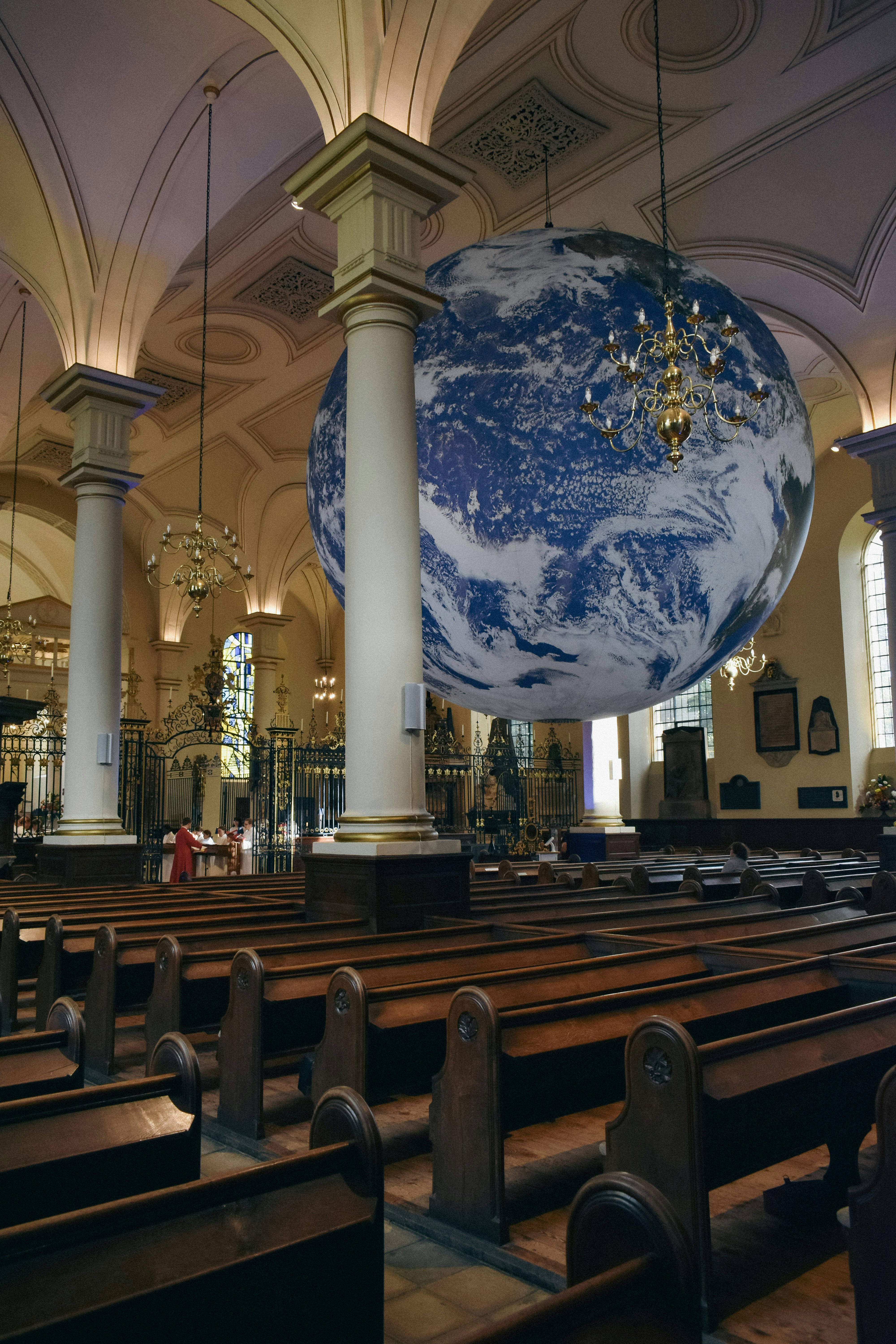 a church with a large globe hanging from the ceiling