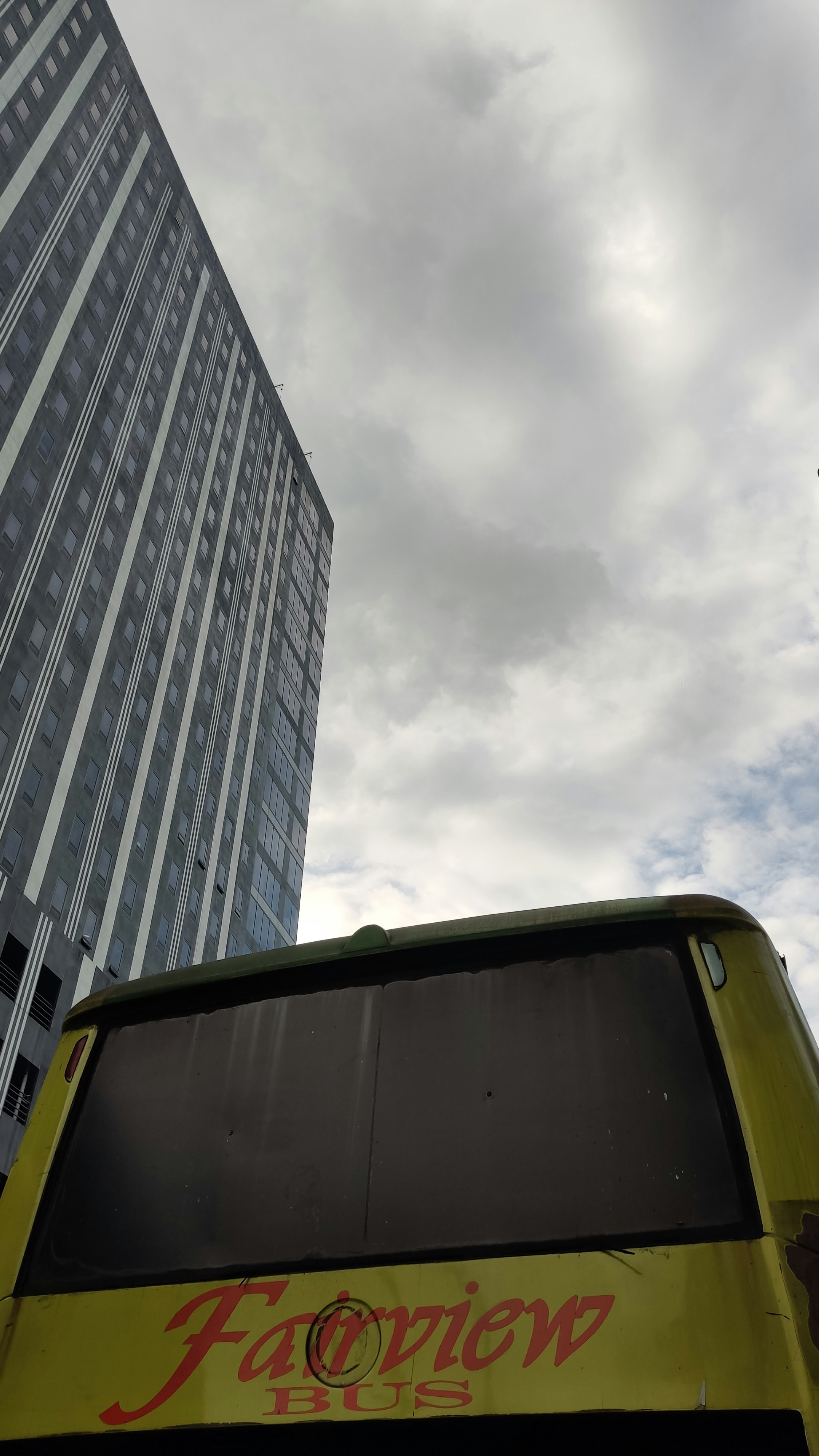 A yellow bus parked in front of a tall building photo – Free City Image ...