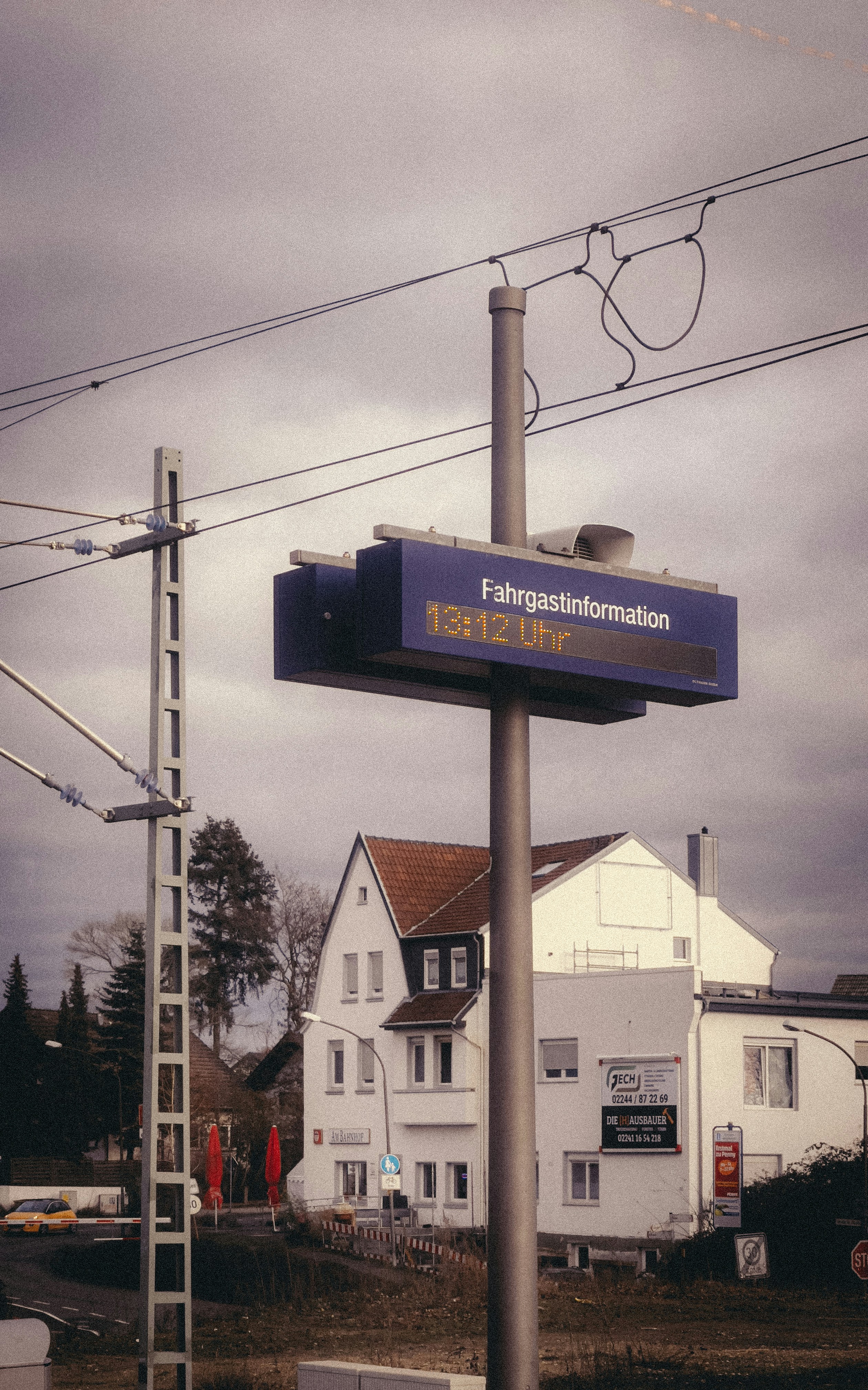 Fahrgastinformation Sign Amid Overhead Wires on a Quiet German Street