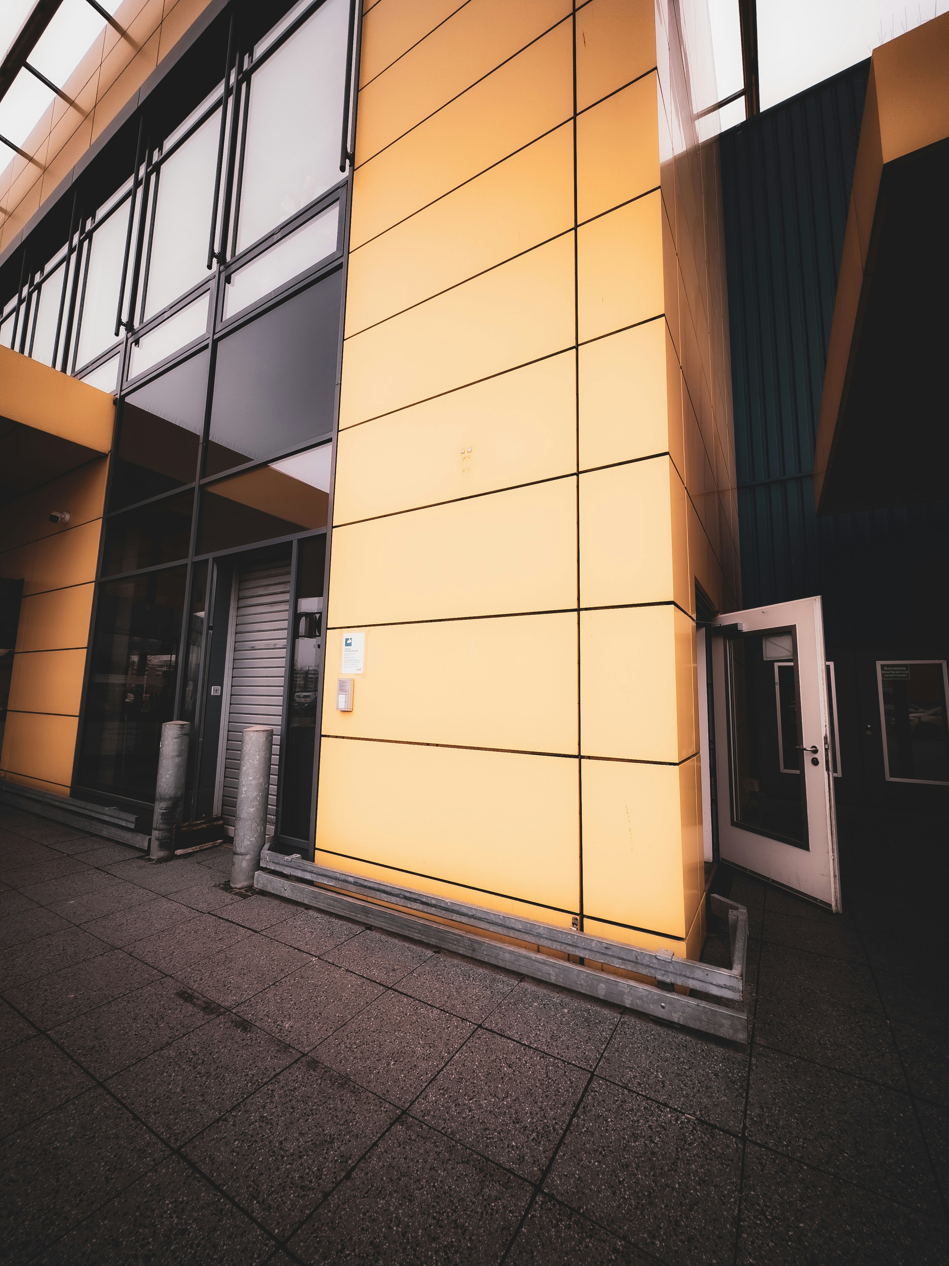 Golden Grid: A Tilted Facade of Yellow Panels and Glass