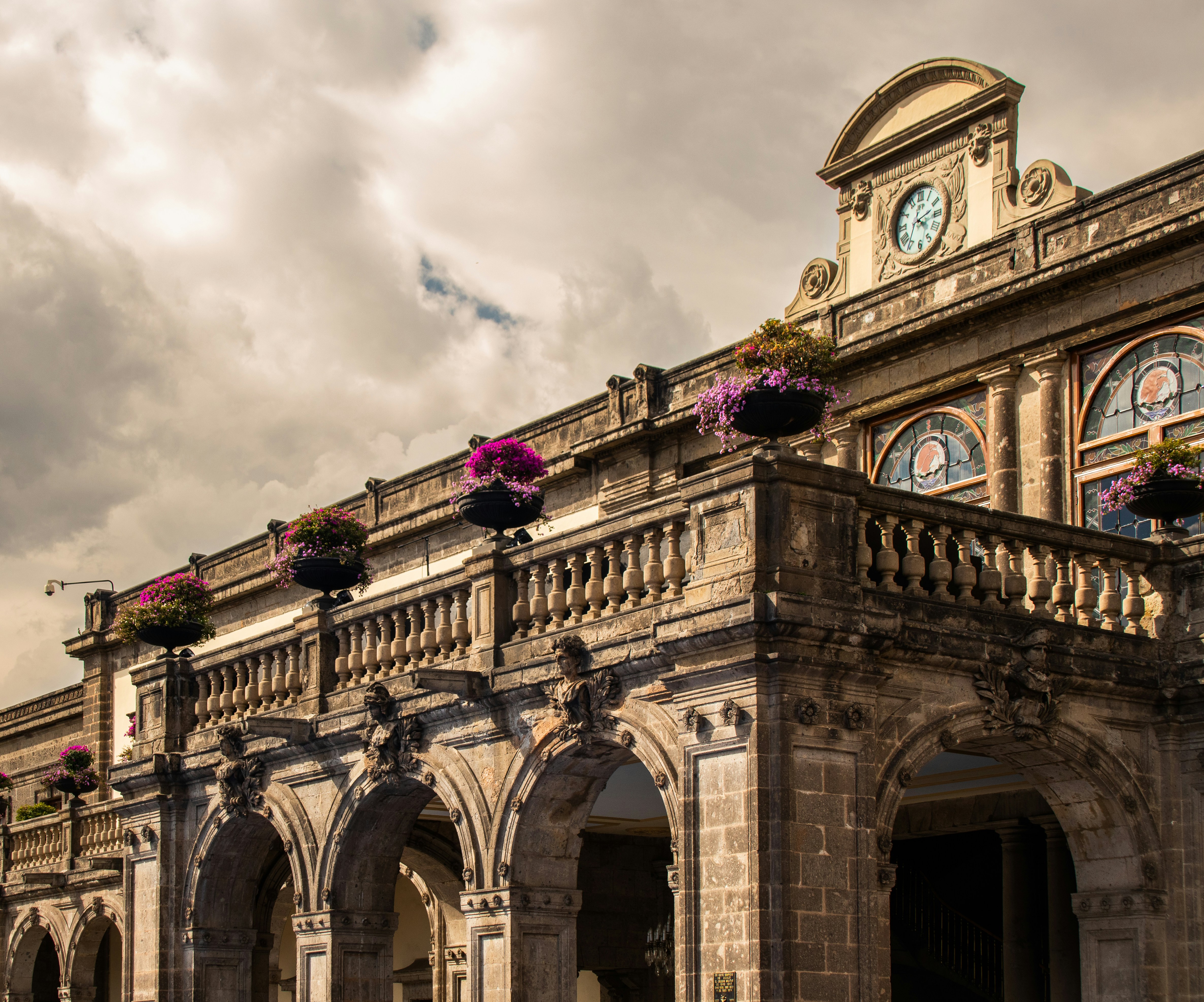 Stone Terrace with Floral Accents Under a Clocked Pavilion