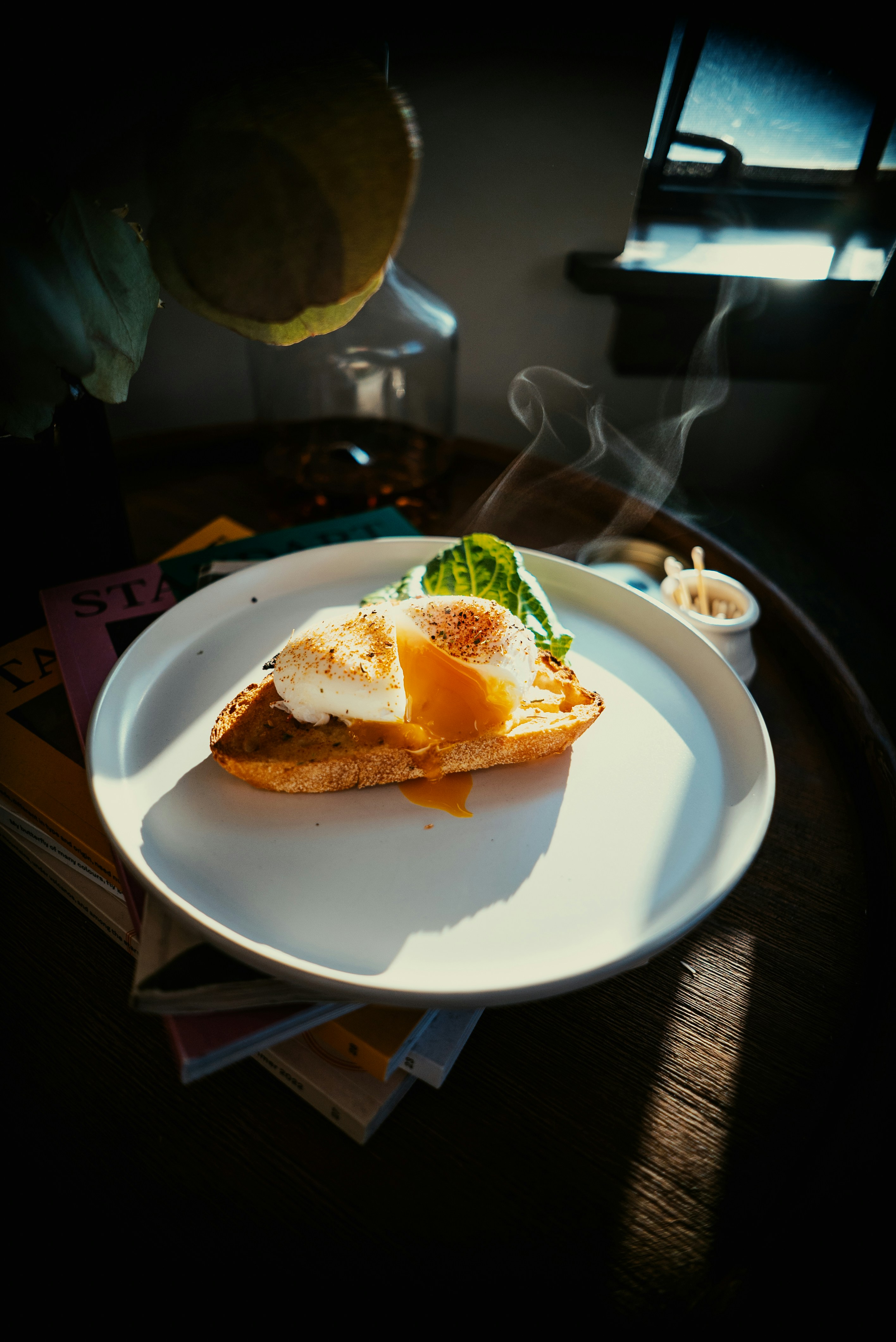 Une assiette blanche surmontée d’un sandwich sur une table en bois ...