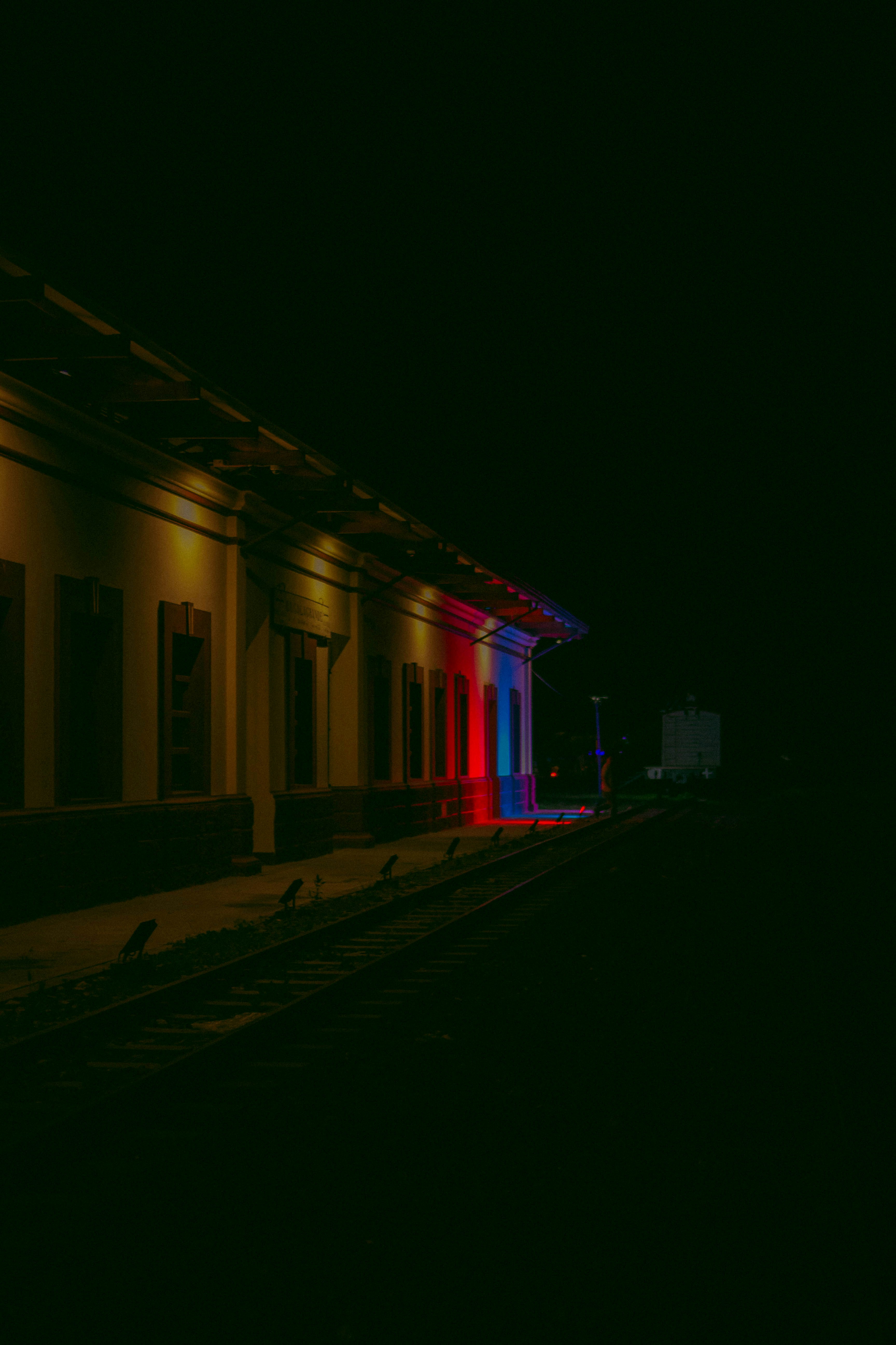 a train station at night with colorful lights