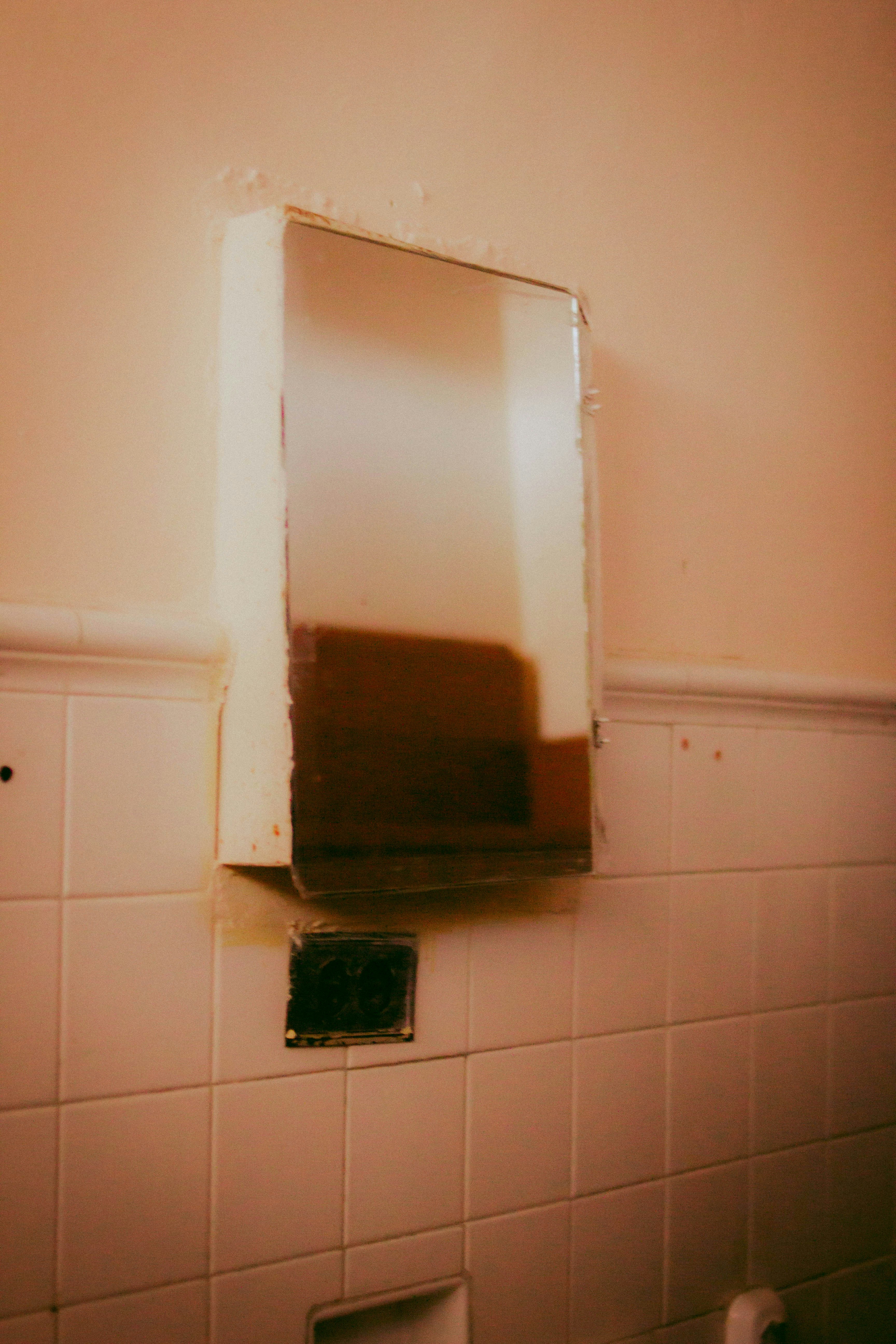 Pink Glow on a Wall-Mounted Mirror Cabinet in a Quiet Bathroom