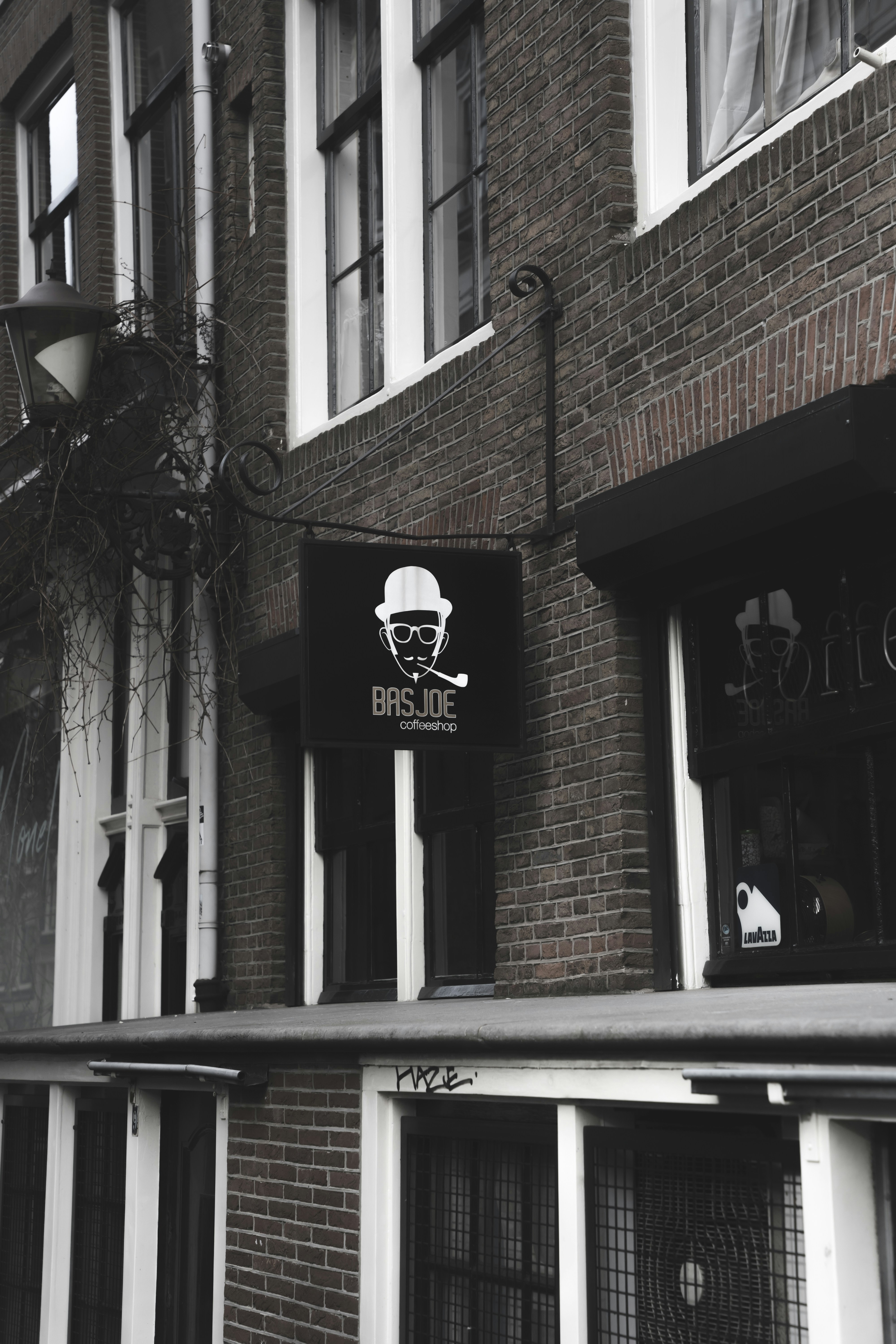 Bas Joe Sign on Brick Facade: A Quiet Monochrome Street Portrait