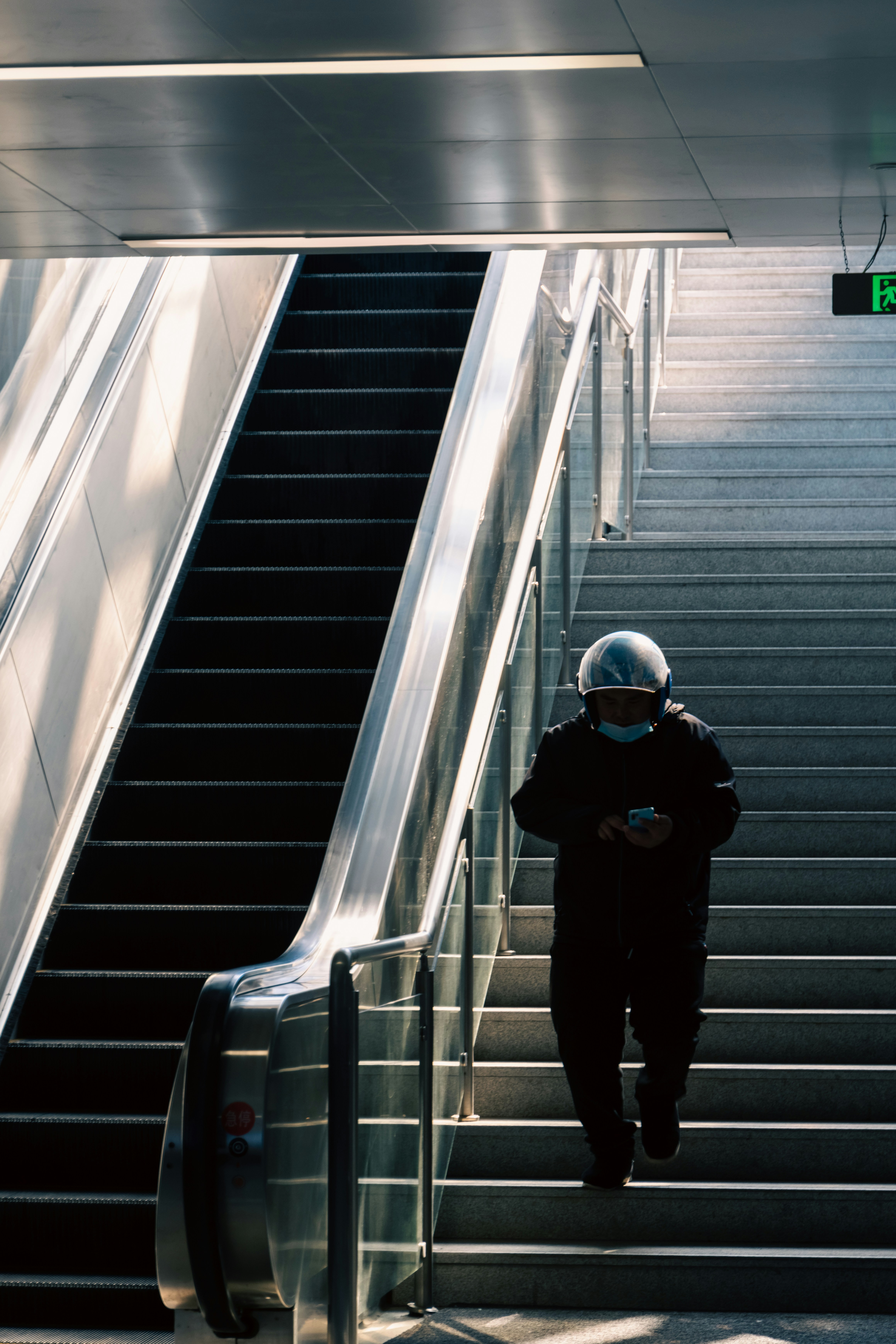 a man in a helmet is walking down a flight of stairs