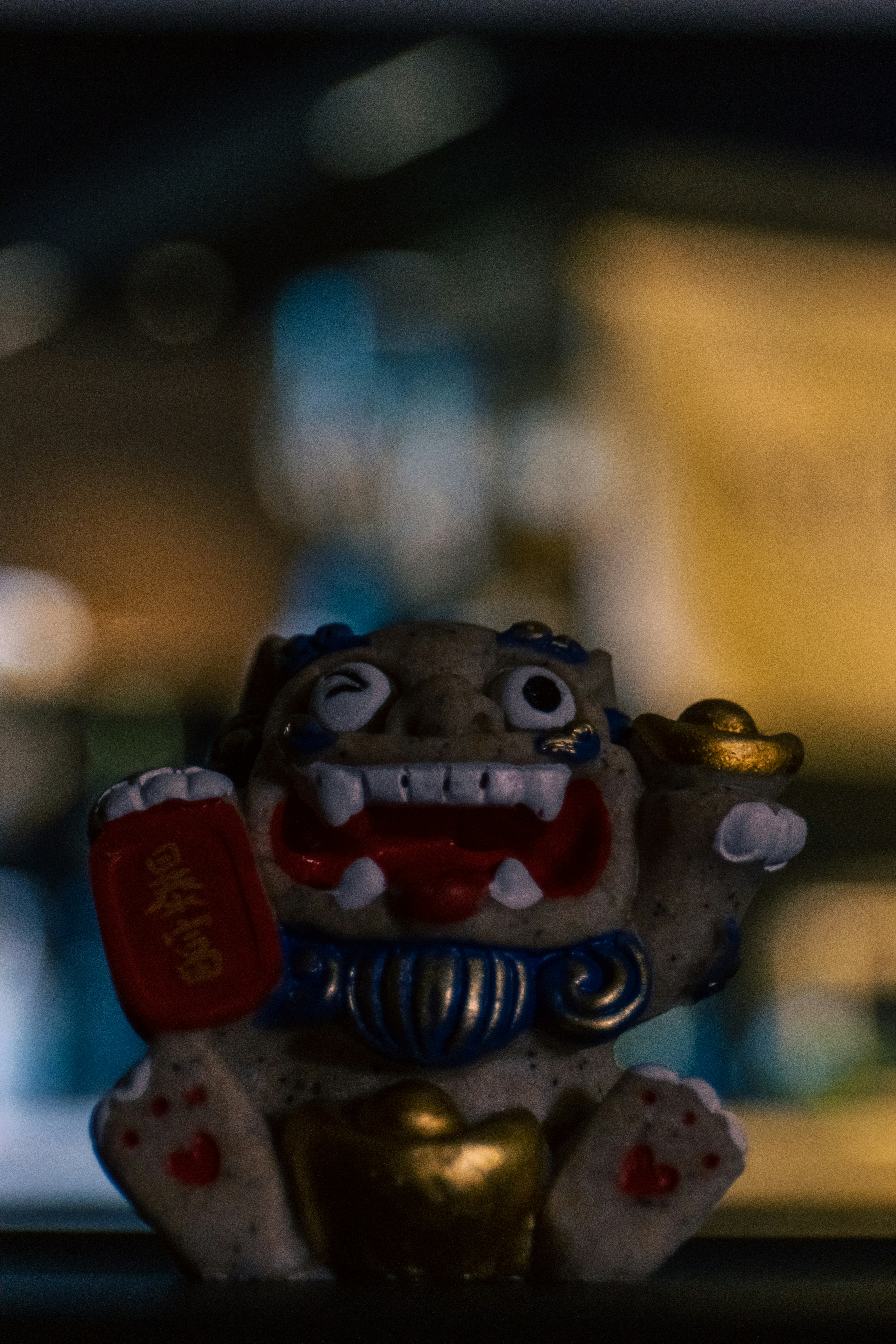 a small figurine of a demon holding a red object