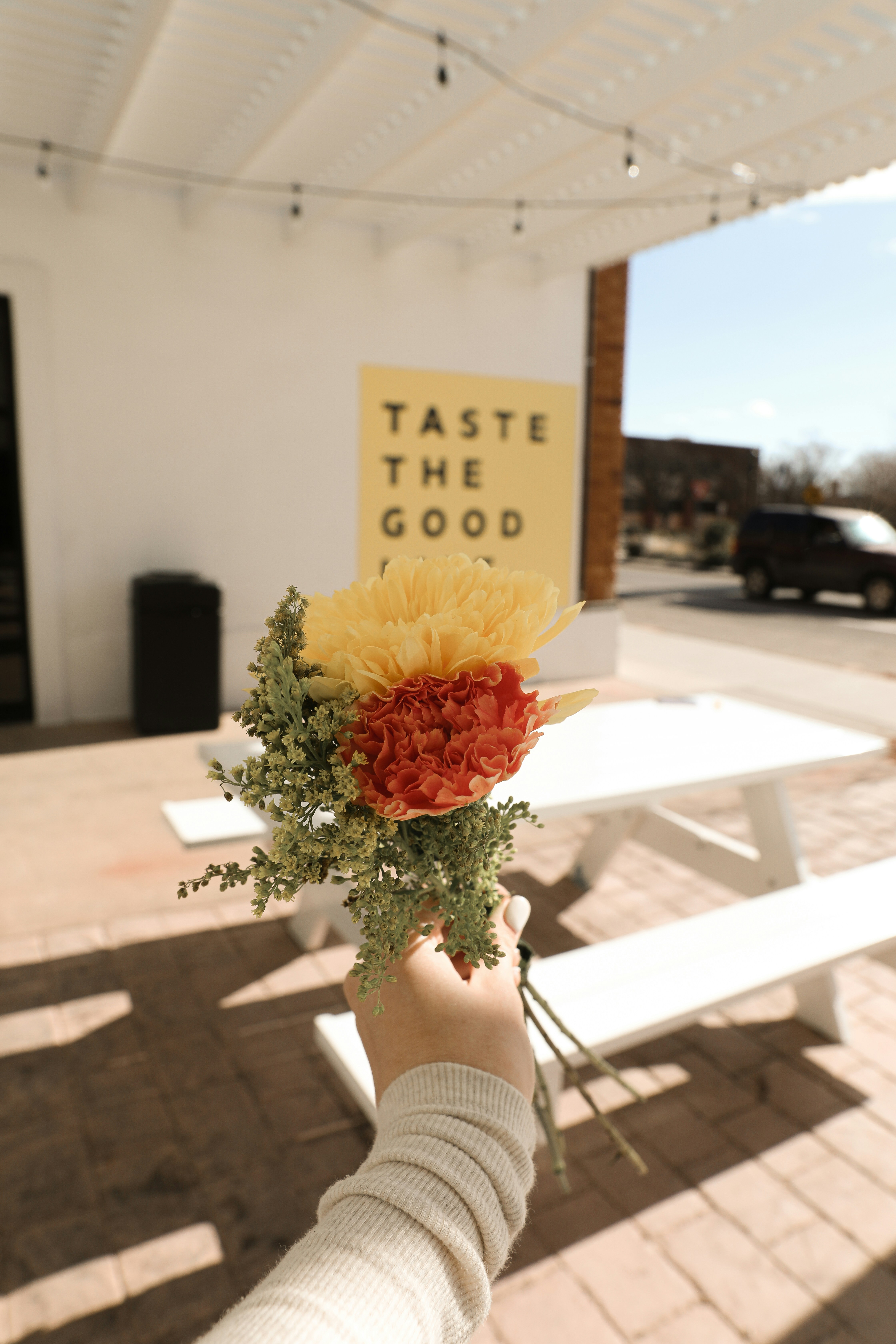 Sunlit Courtyard Bouquet Framed by a 'Taste the Good' Sign
