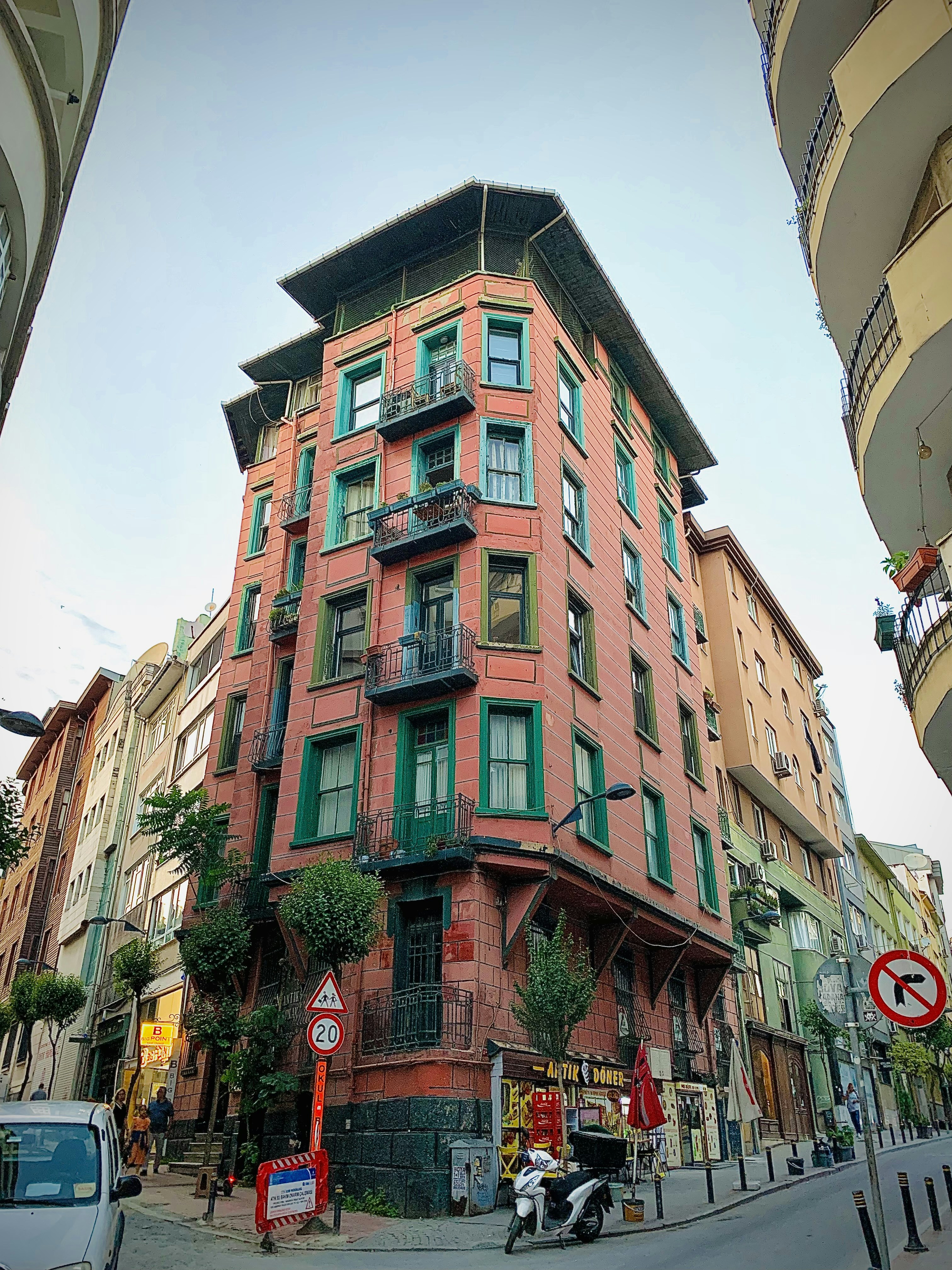 Crimson Corner: Verdant Shutters on a Sunlit European Street