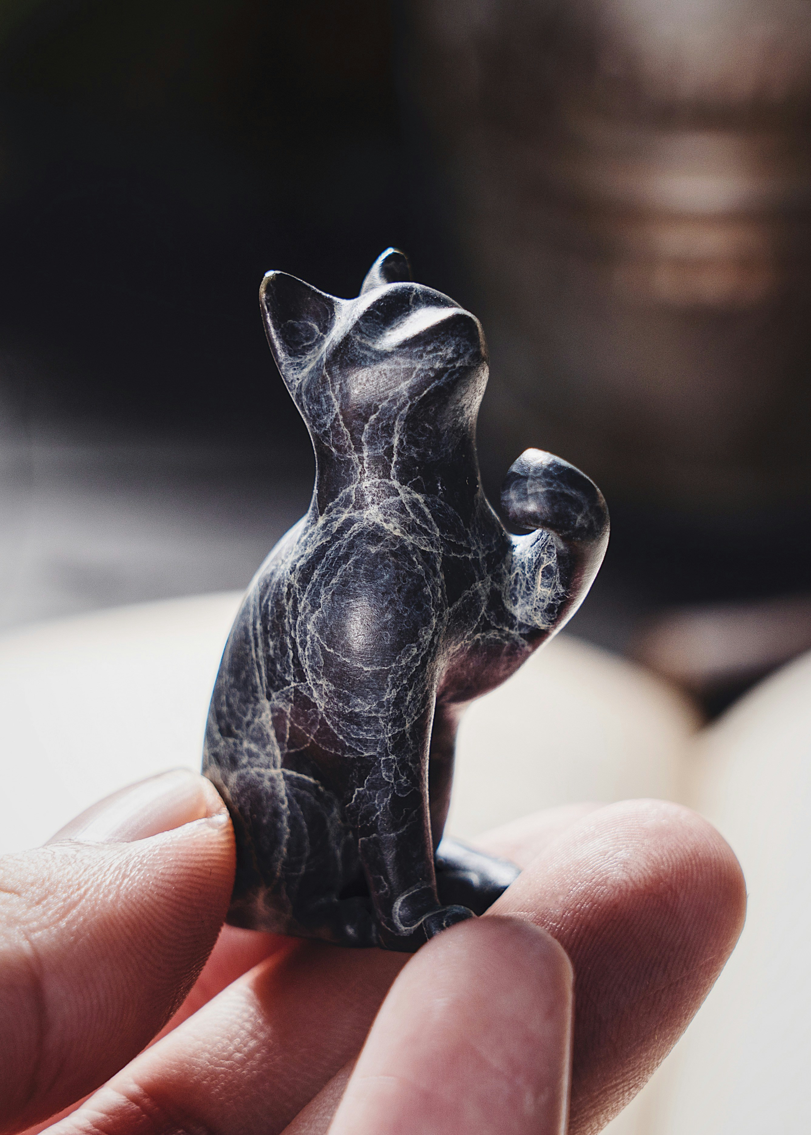 Veined Onyx Cat in Hand: A Marble Figurine with Silky Focus