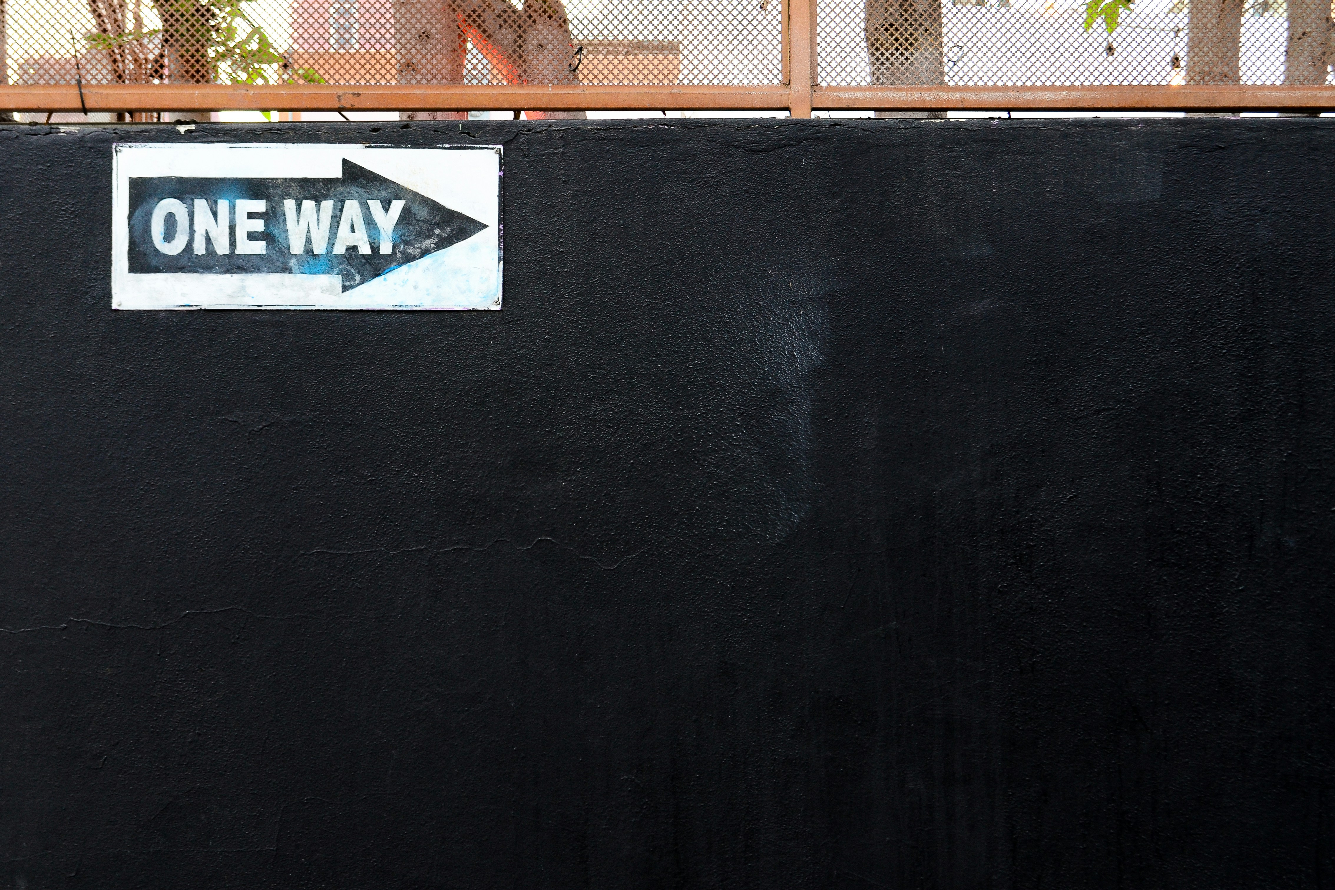 A one way sign on a black wall photo – Free Paper Image on Unsplash