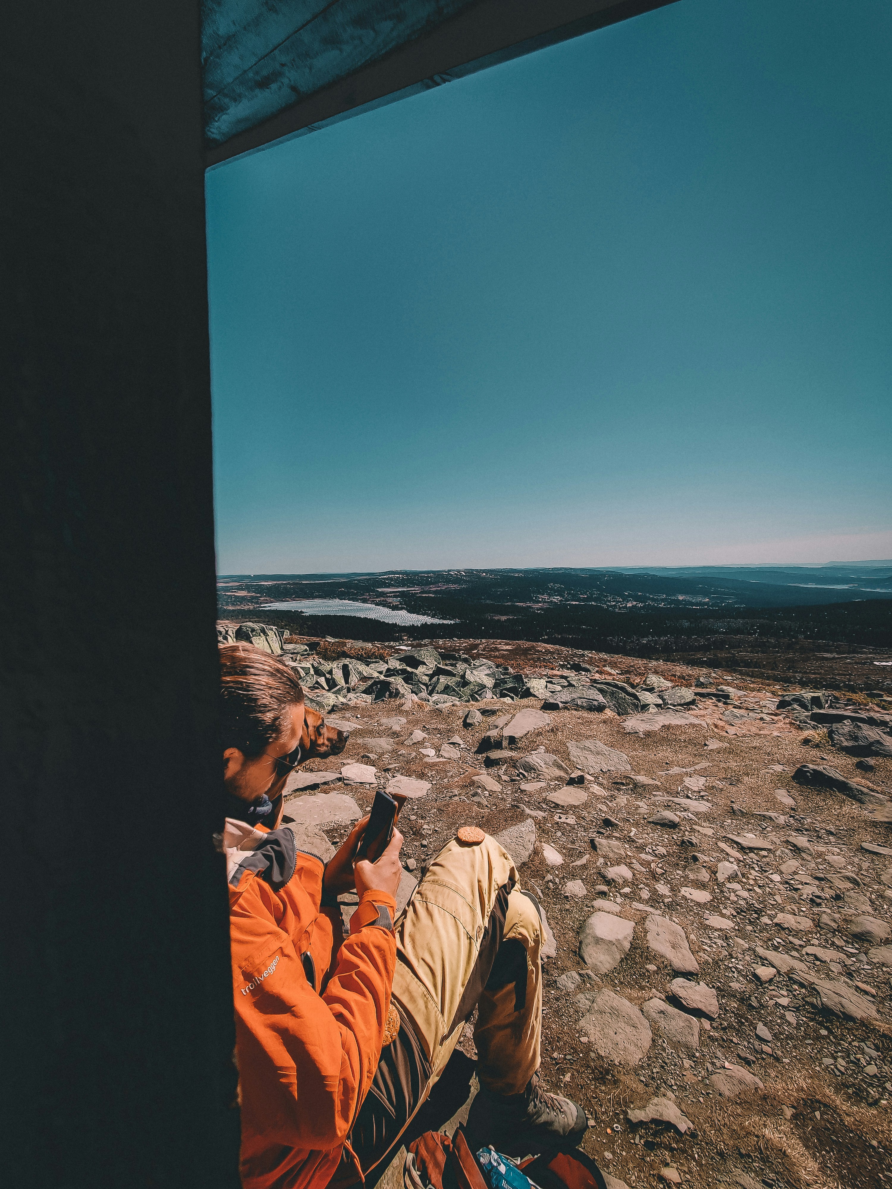 Ridgeline Quiet: A Hiker Checks a Phone at the Edge