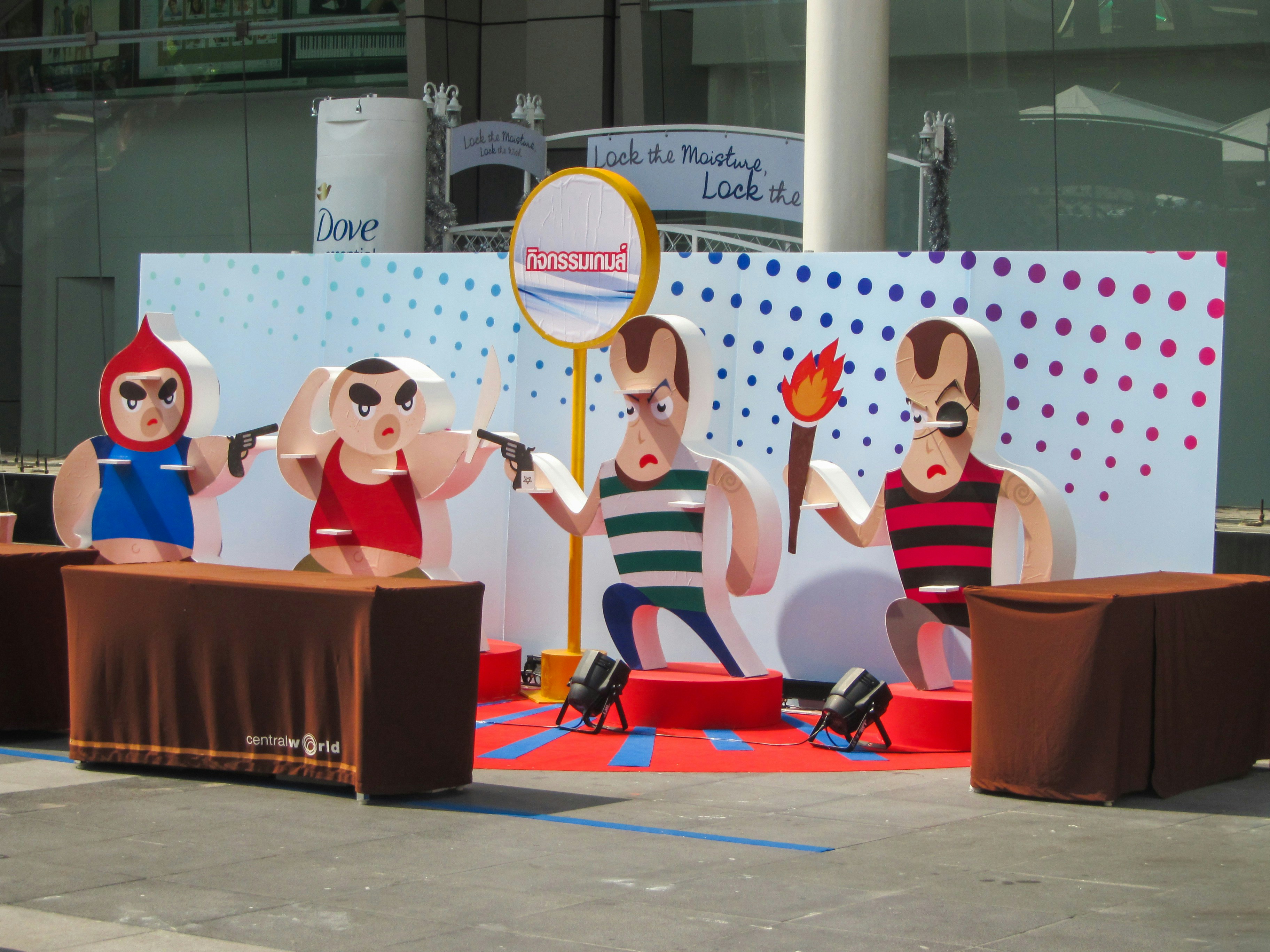 Colorful cartoon wrestler standees form a playful street-stage display against a dotted backdrop.