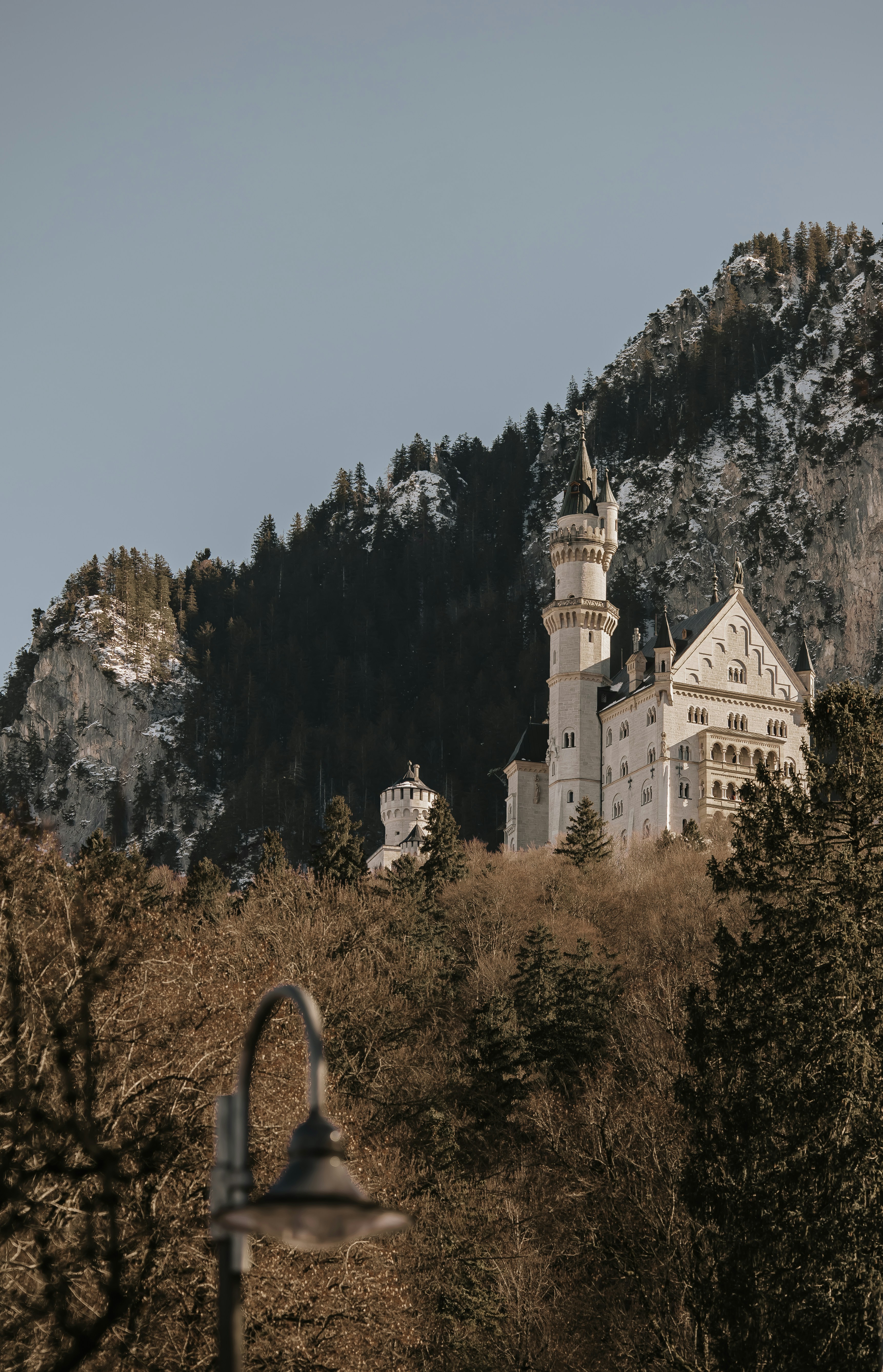 A large white castle sitting on top of a lush green hillside photo ...
