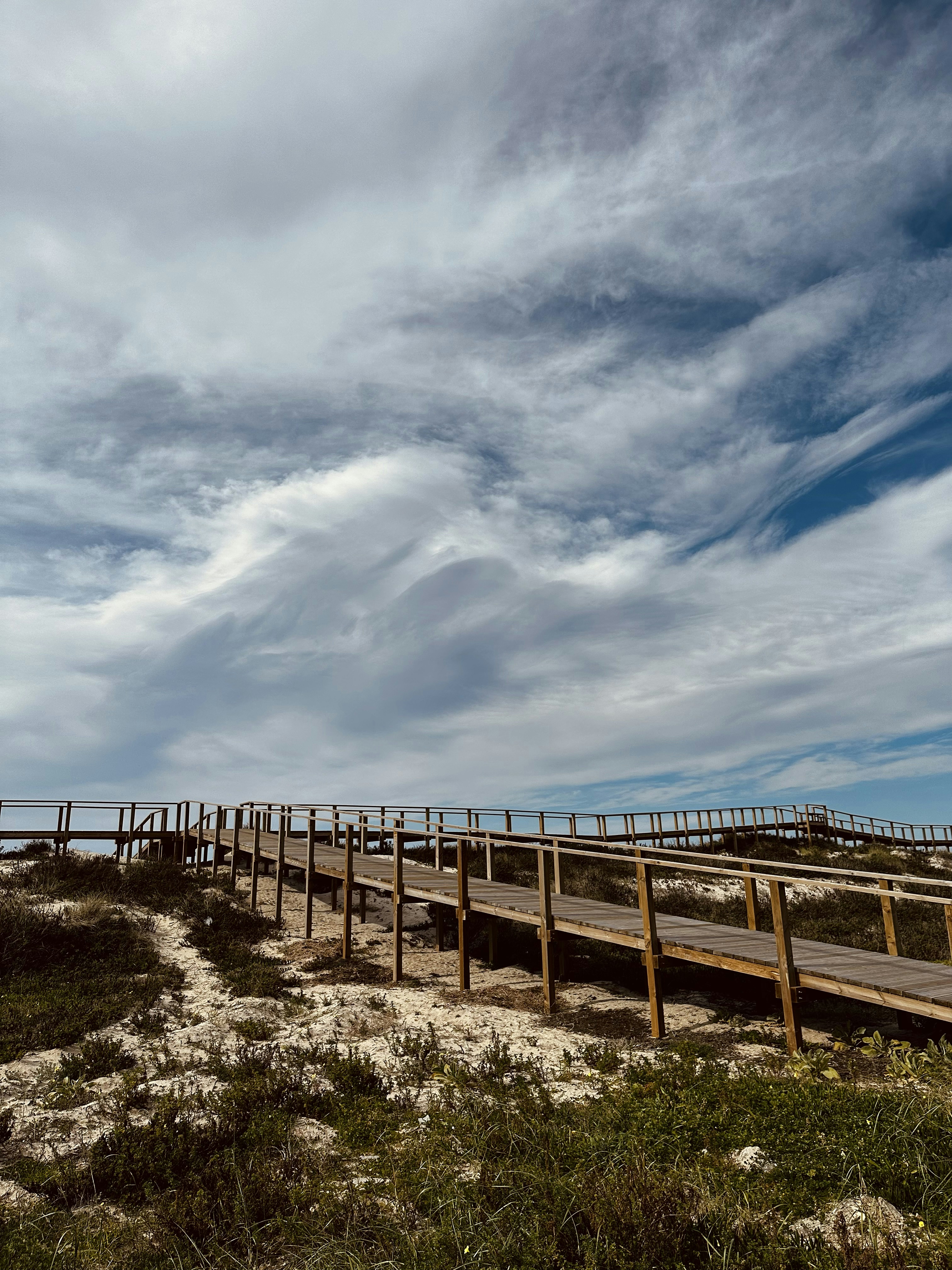 A wooden walkway leading to the beach under a cloudy sky photo – Free ...