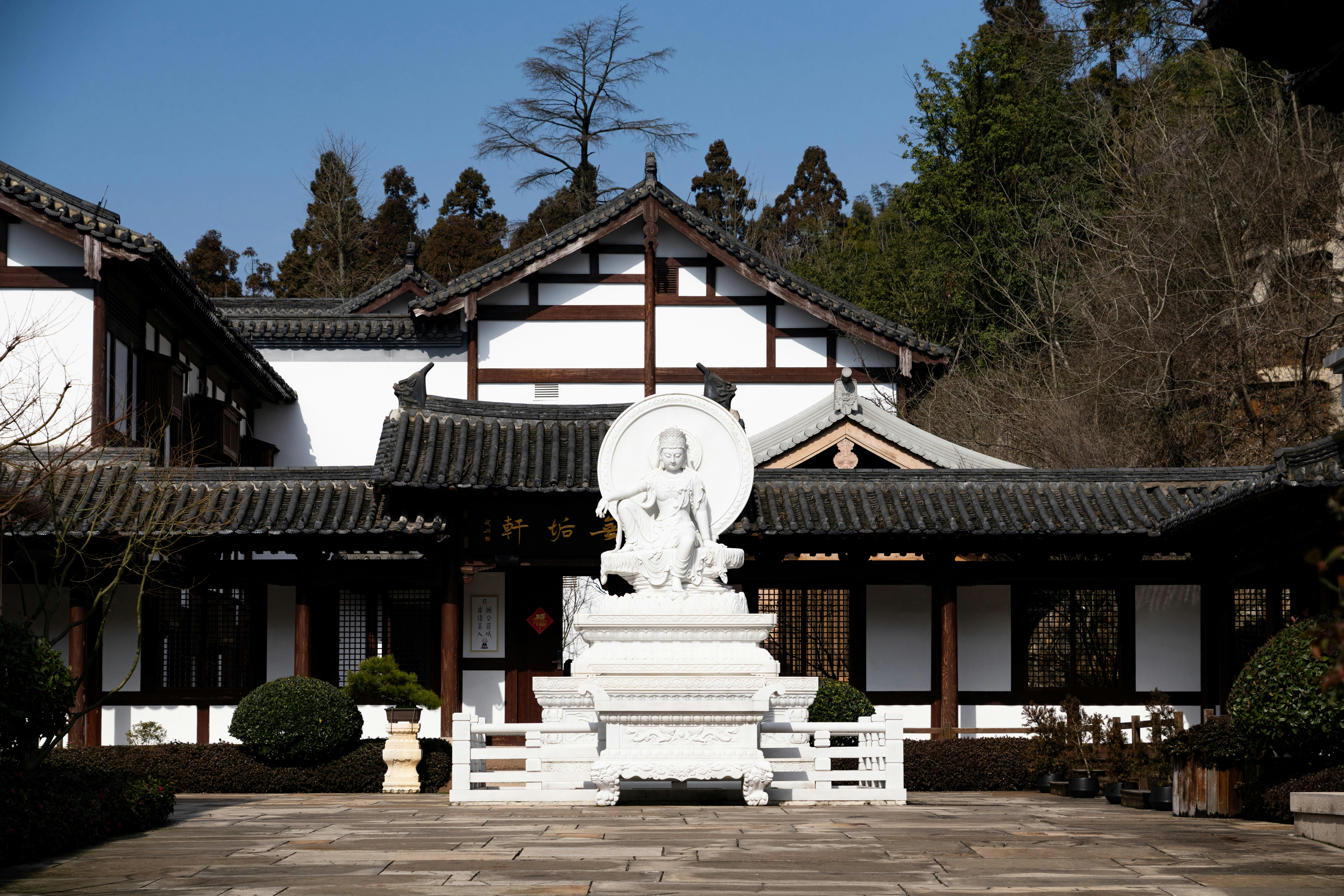 Zen Sentinel in White: A Temple Courtyard Shrine Framed by Timbered Eaves