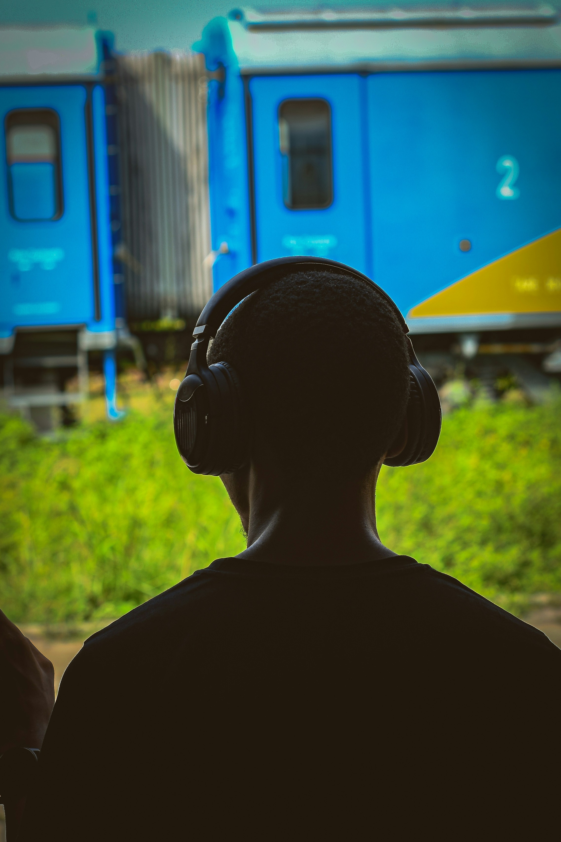 A person with headphones standing in front of a train photo – Free ...