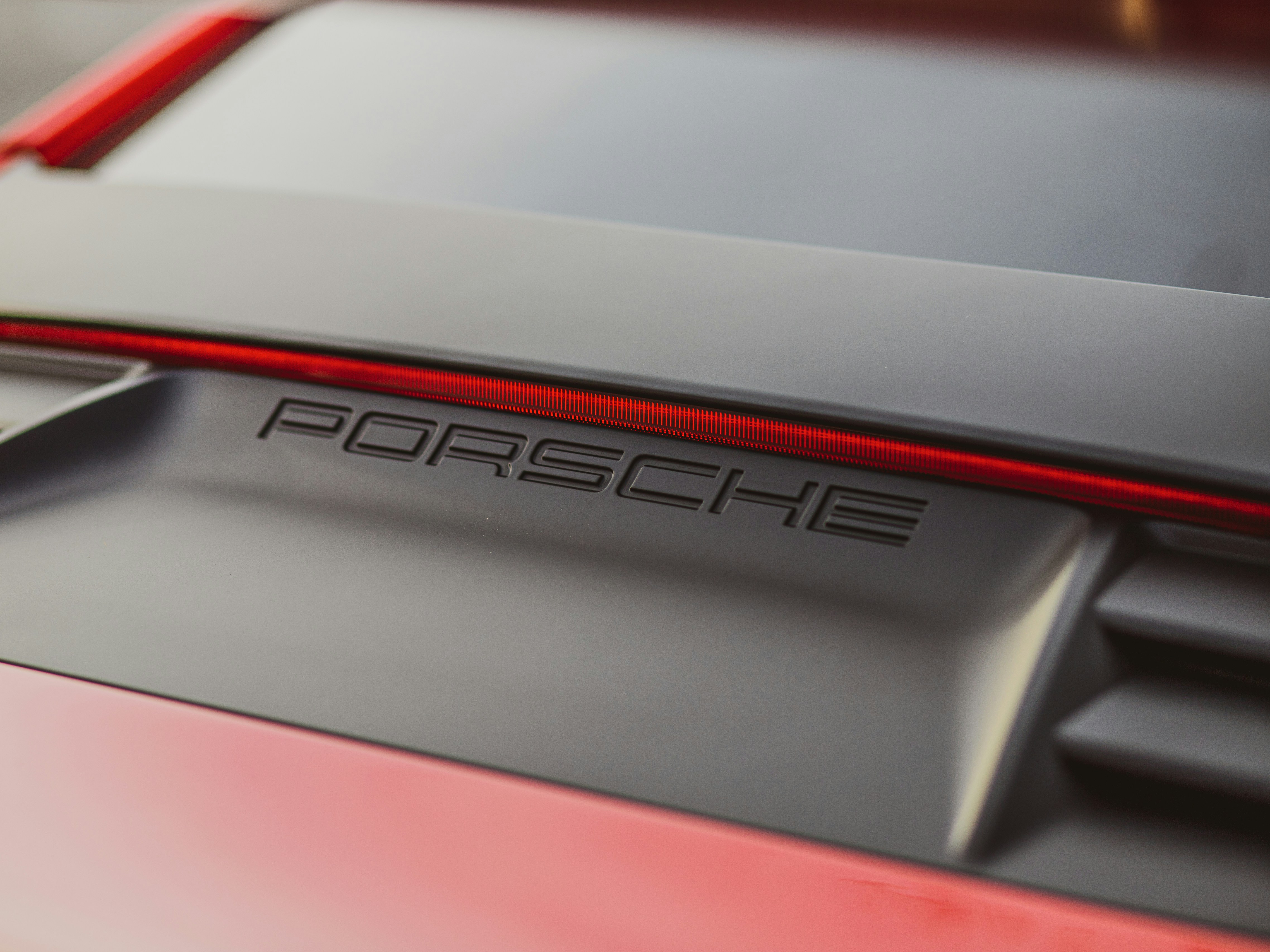 A close up of a porsche logo on a car photo – Free Red Image on Unsplash