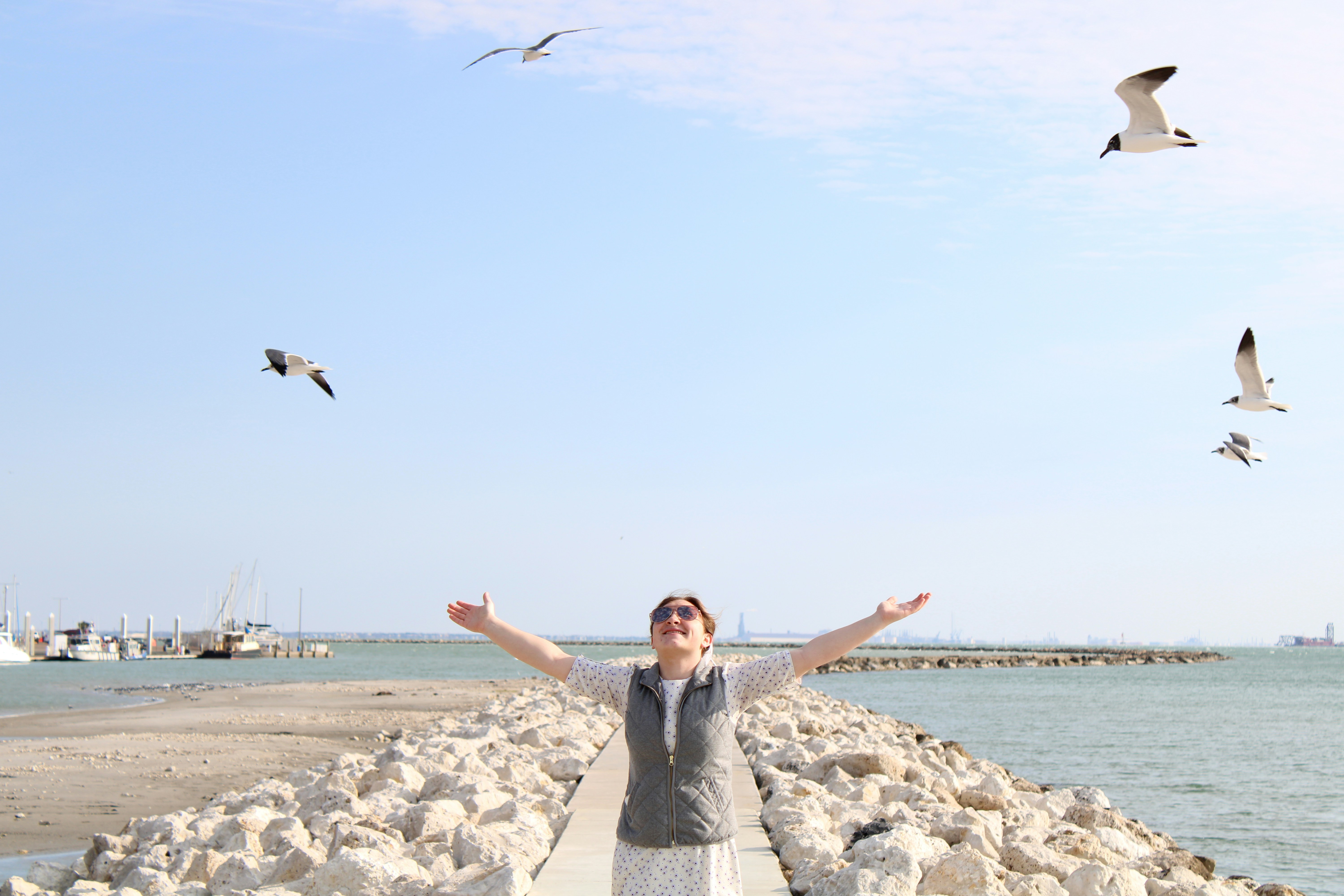 Open Arms at the Breakwater: A Joyful Moment by the Sea
