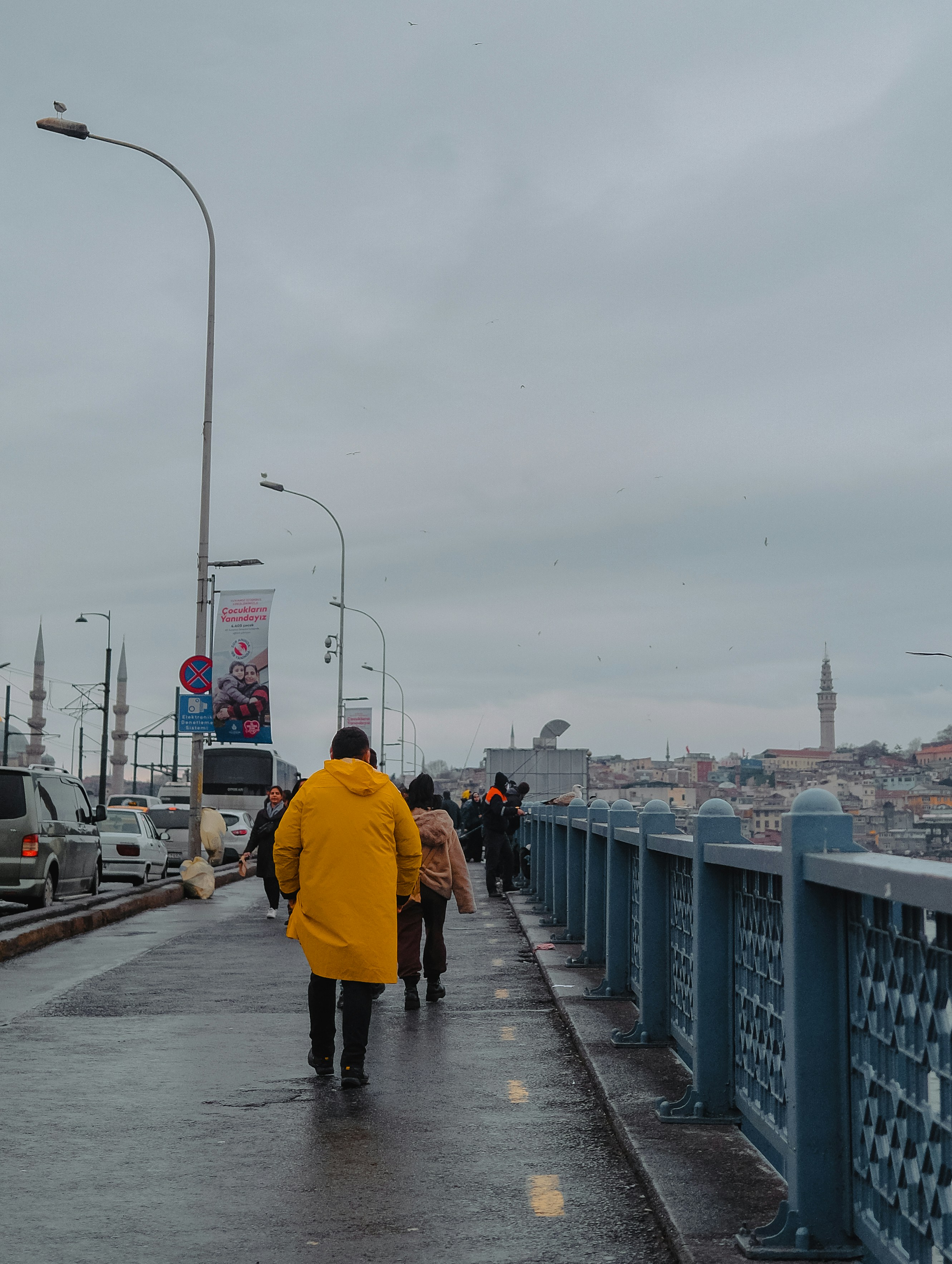 A group of people walking across a bridge photo – Free Coat Image on ...