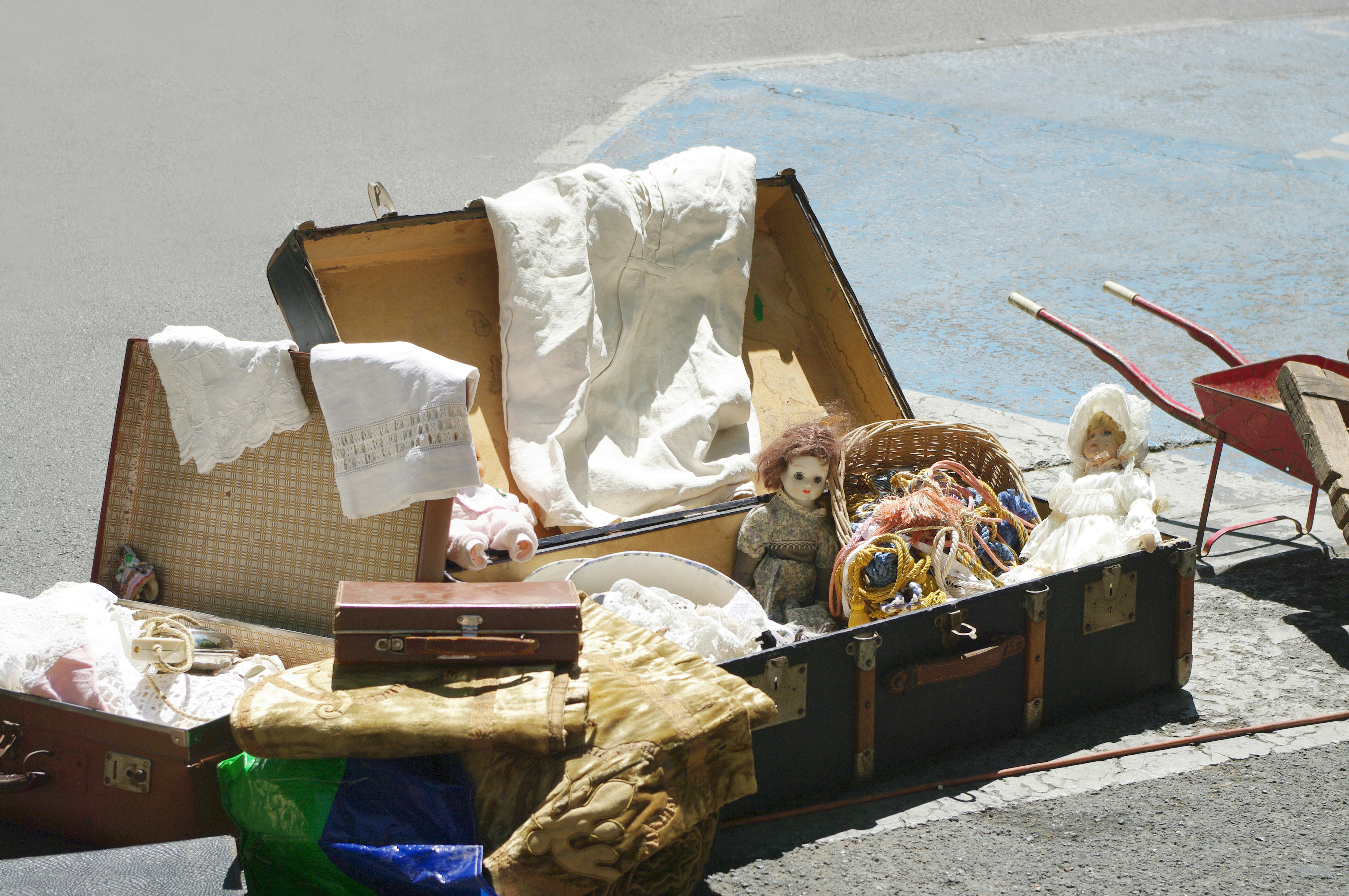 An open suitcase sitting on the side of the road photo – Free Suitcase ...