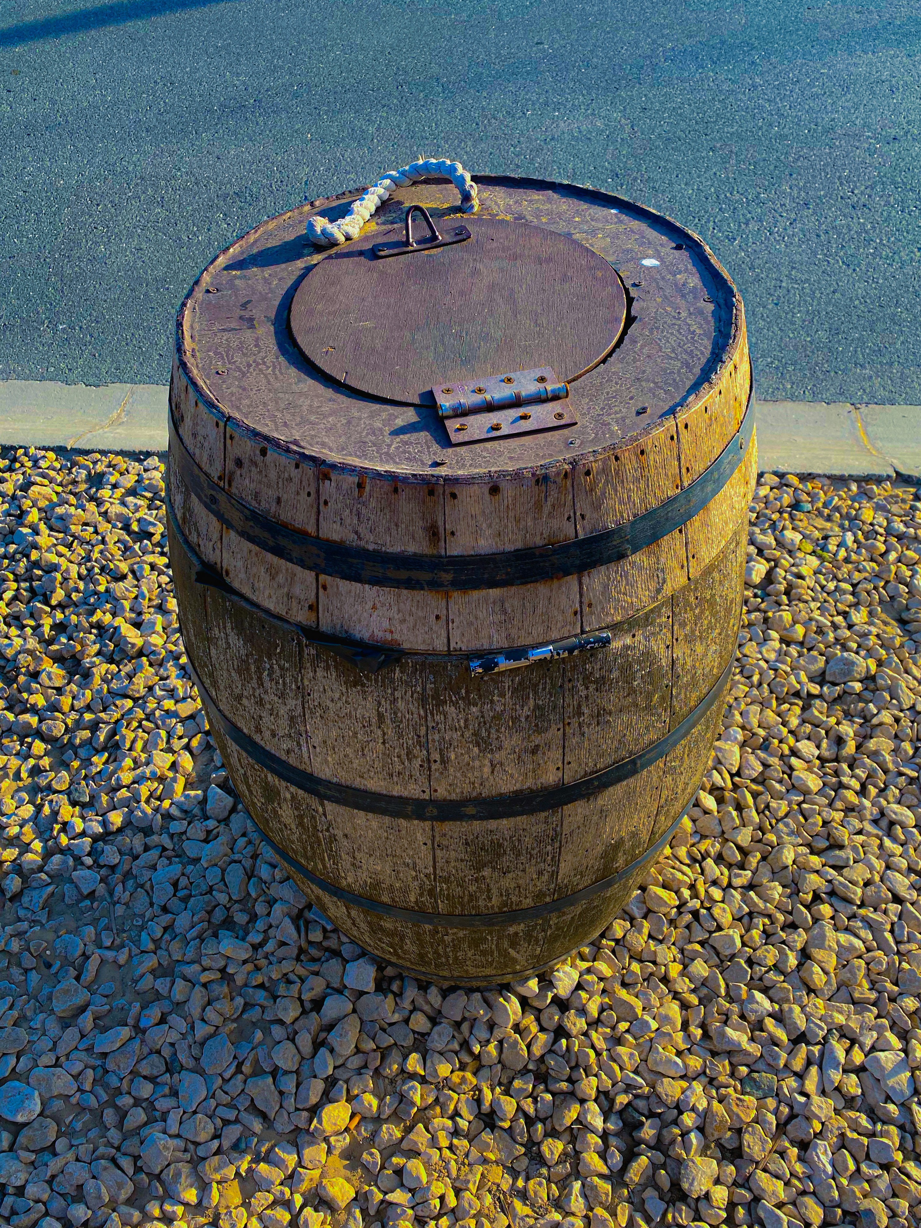 A wooden barrel sitting on top of a gravel road photo – Free Barrel ...