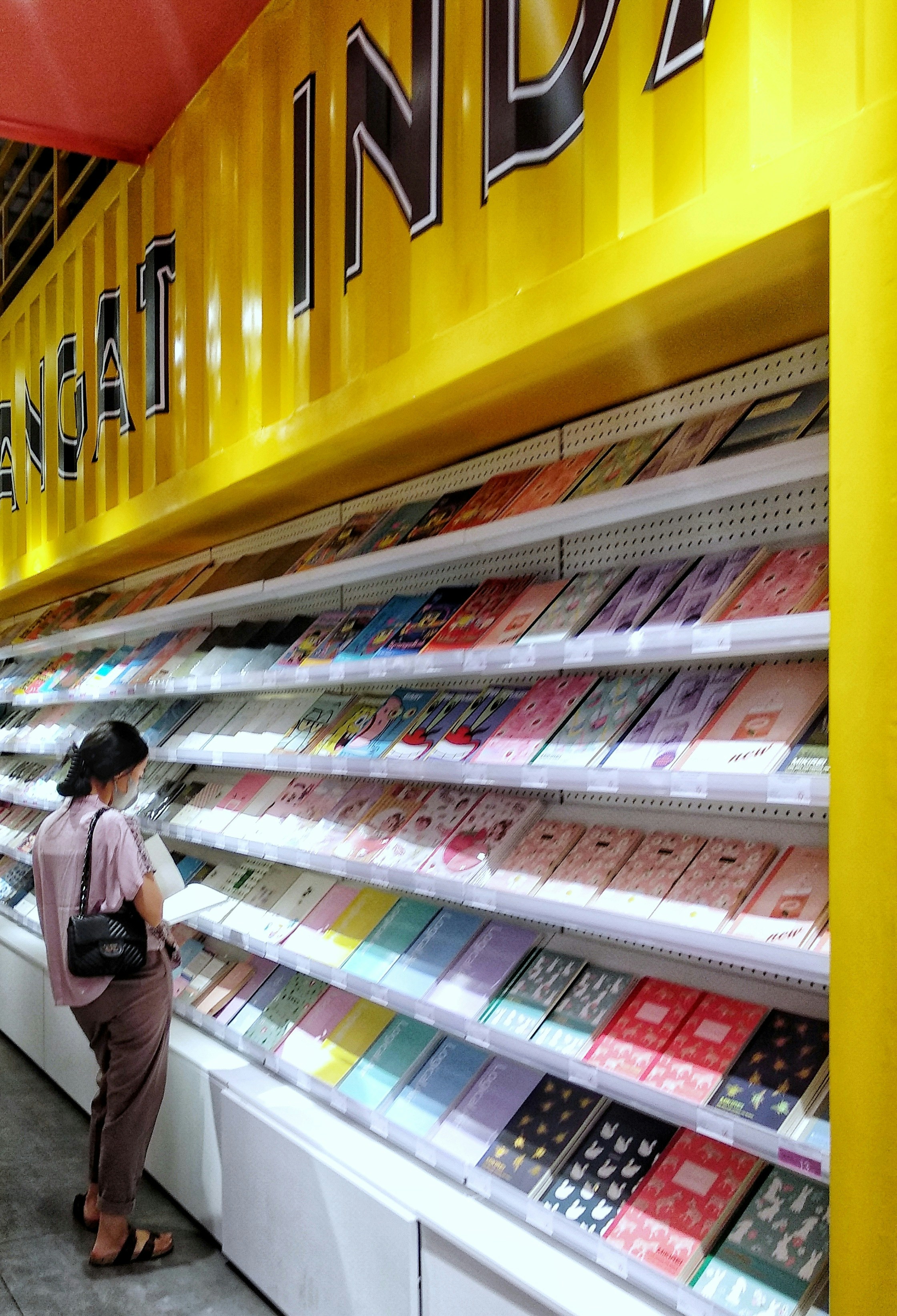 a woman standing in front of a display of books
